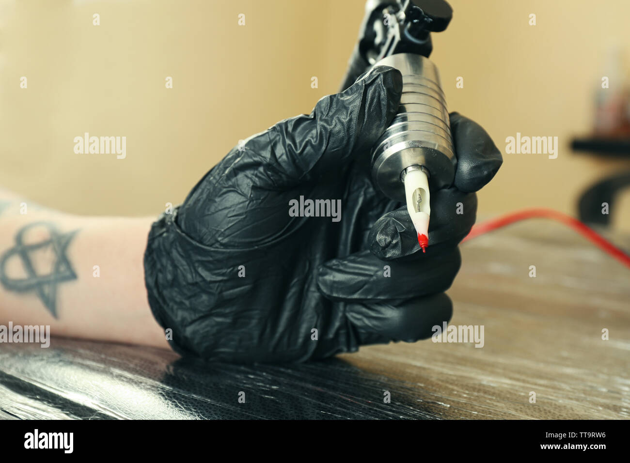 Tattoo artist at work close up Stock Photo - Alamy