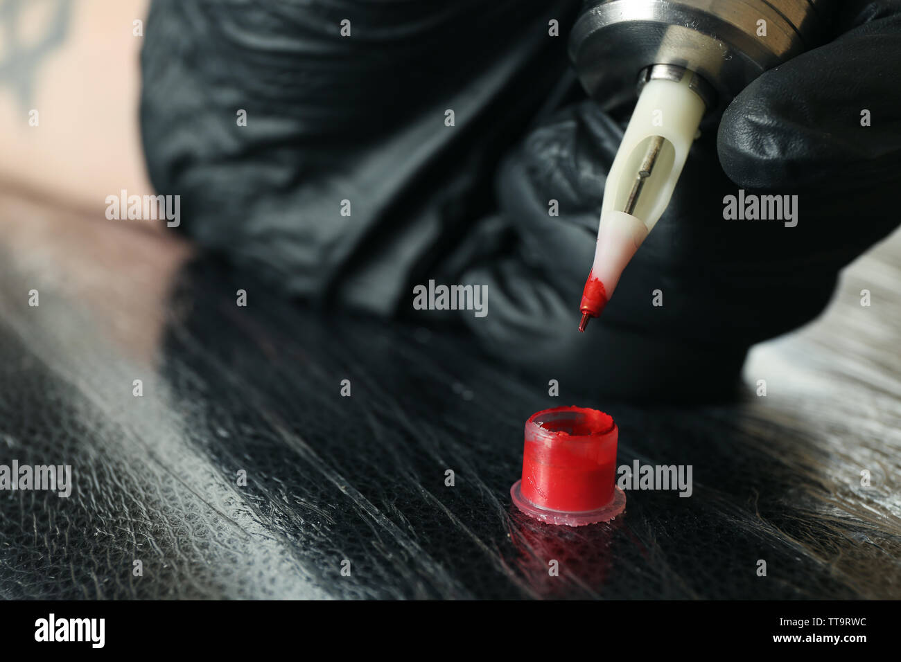 Tattoo artist at work close up Stock Photo - Alamy