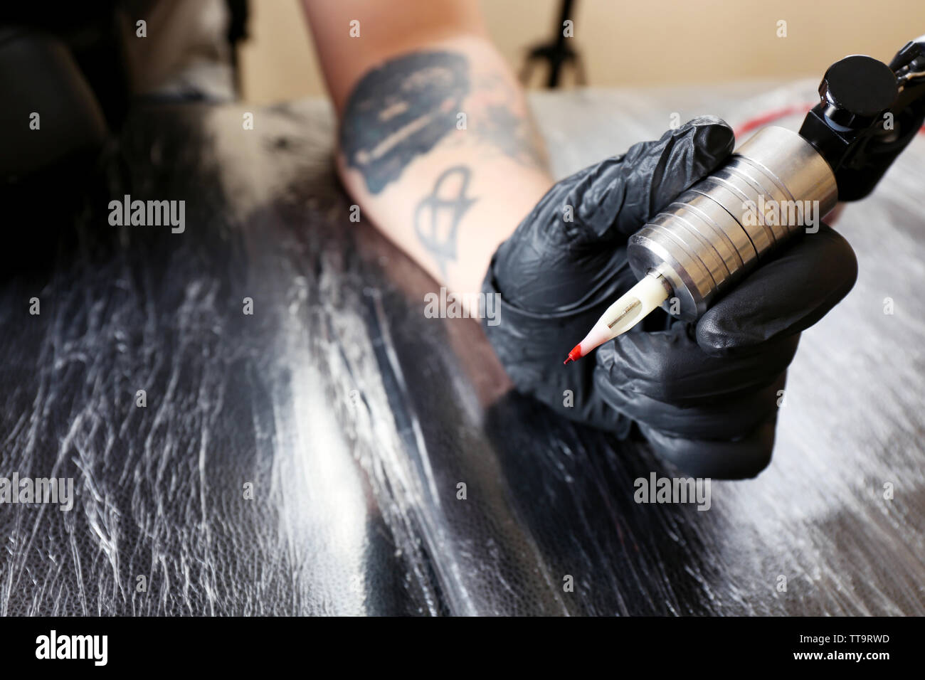 Tattoo artist at work close up Stock Photo - Alamy