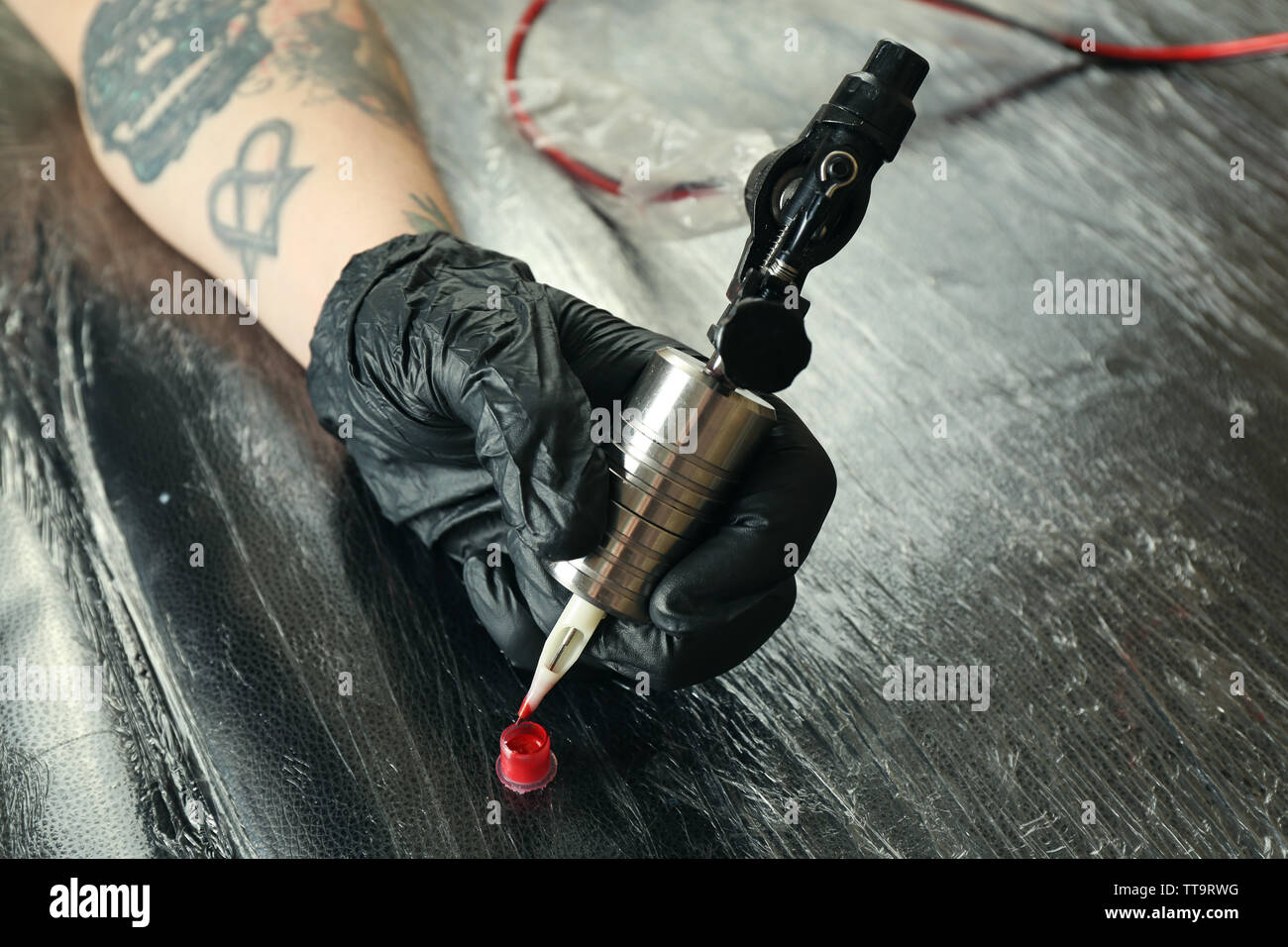 Tattoo artist at work close up Stock Photo - Alamy