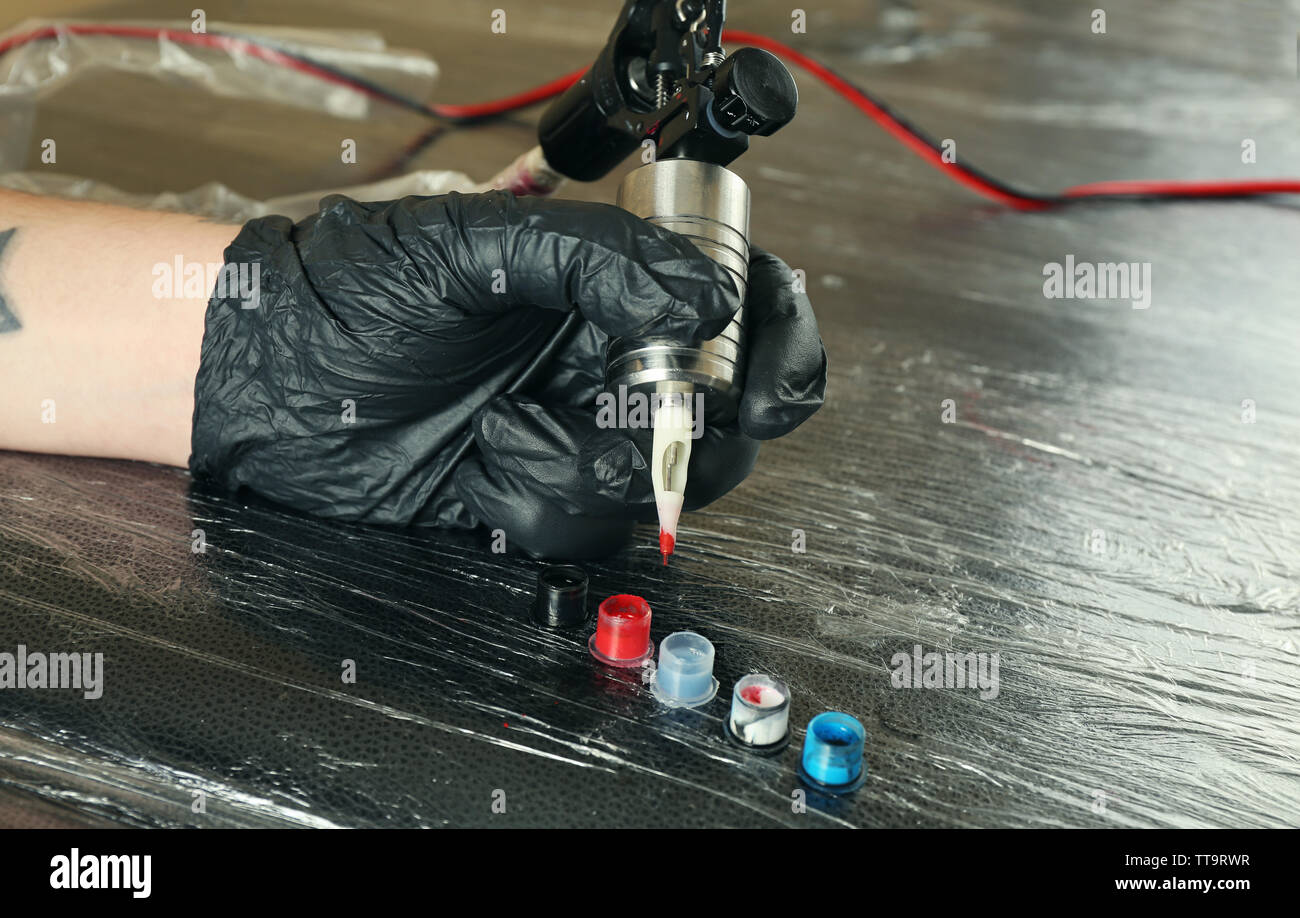 Tattoo artist at work close up Stock Photo - Alamy