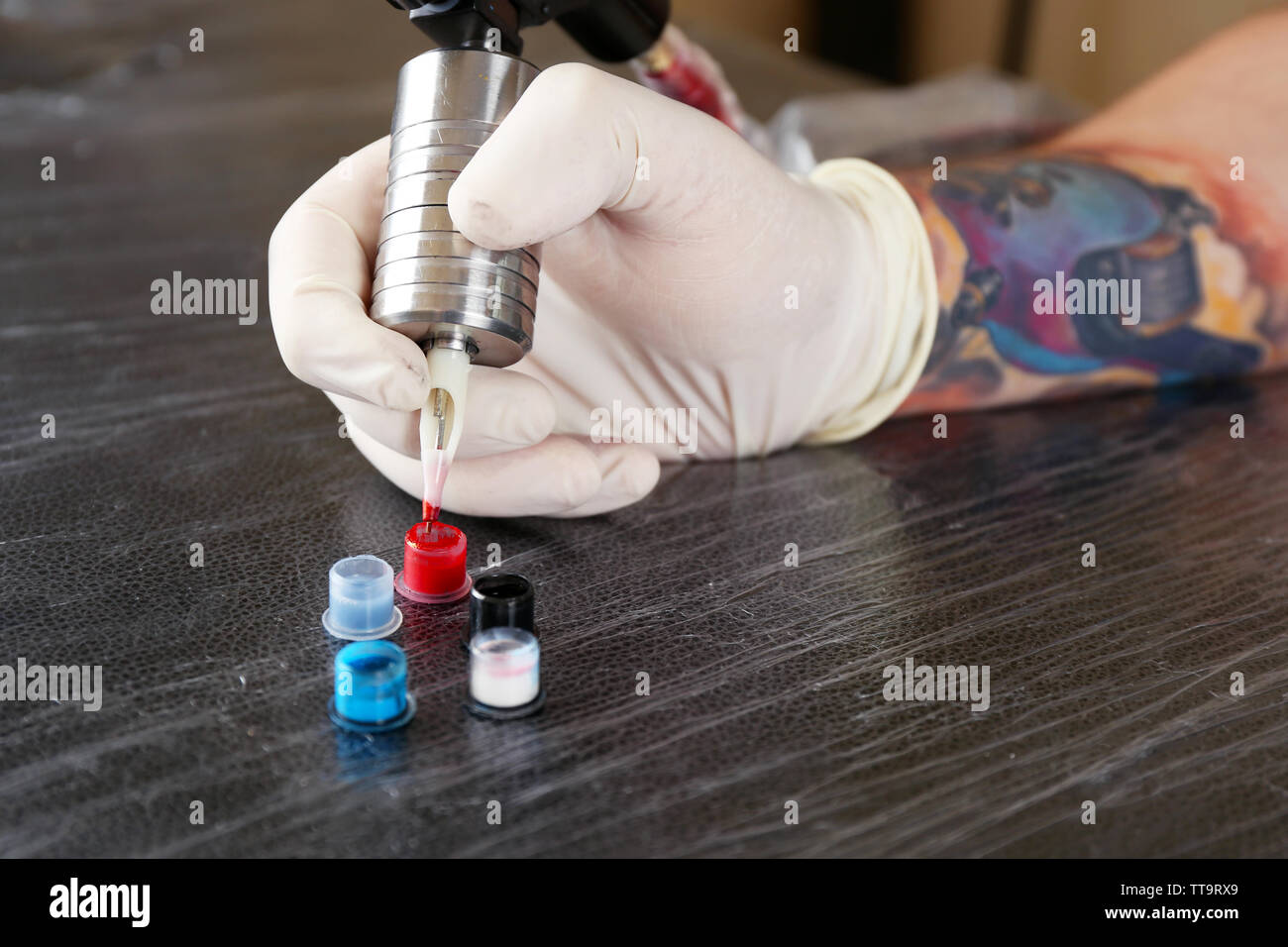 Tattoo artist at work close up Stock Photo - Alamy