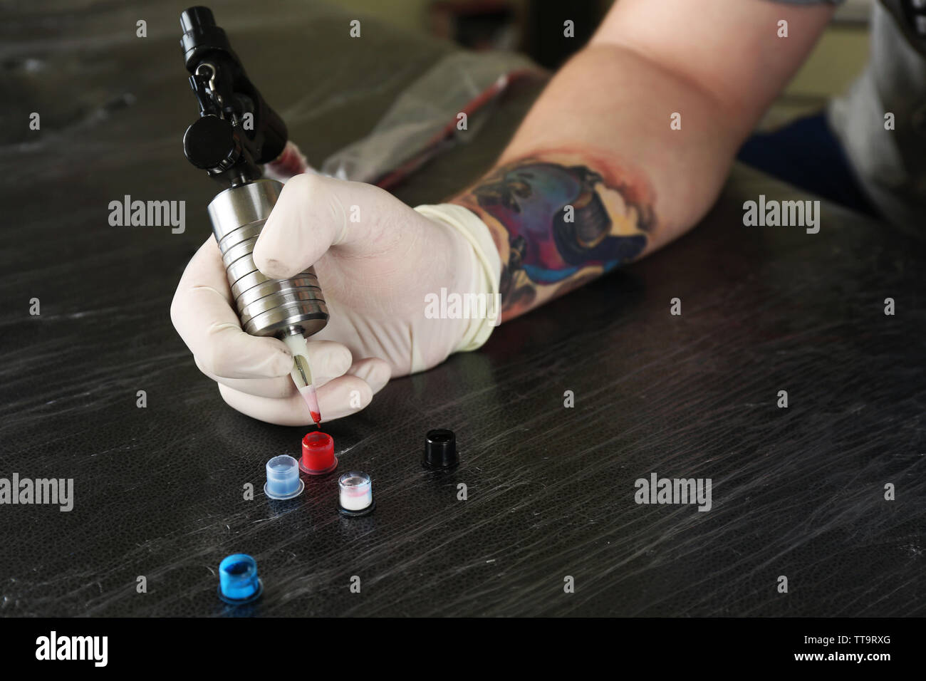 Tattoo artist at work close up Stock Photo - Alamy