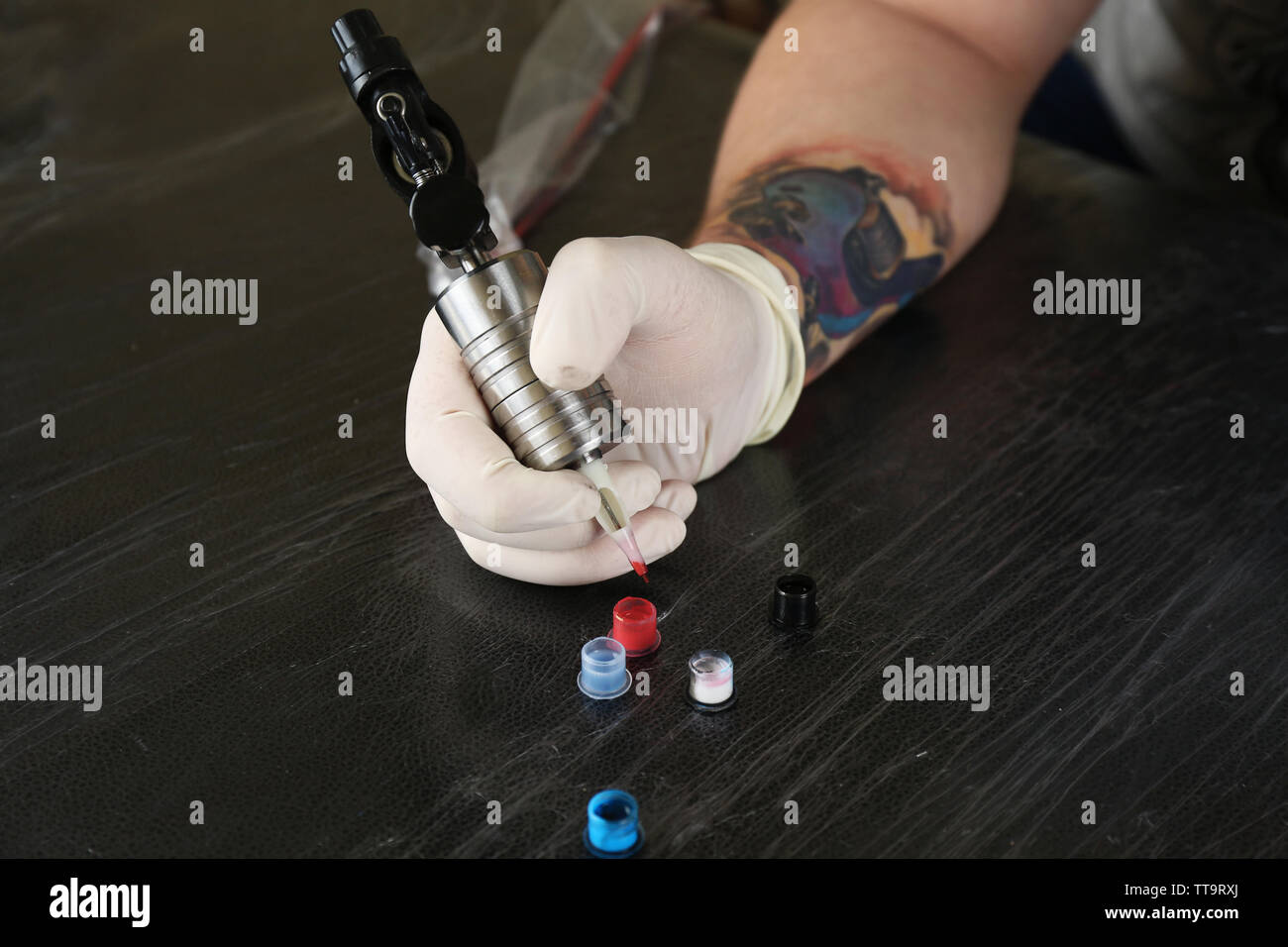 Tattoo artist at work close up Stock Photo - Alamy