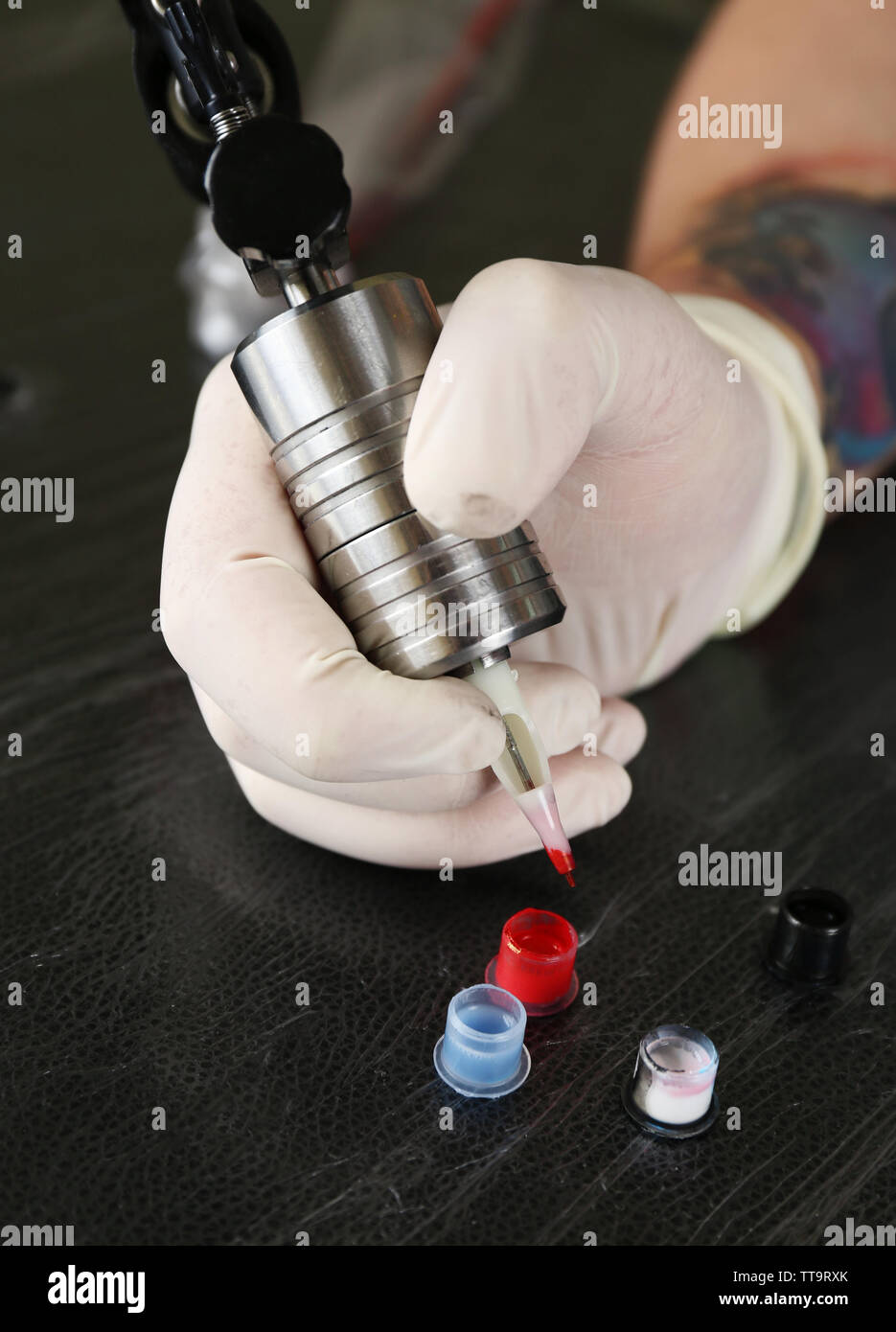 Tattoo artist at work close up Stock Photo - Alamy