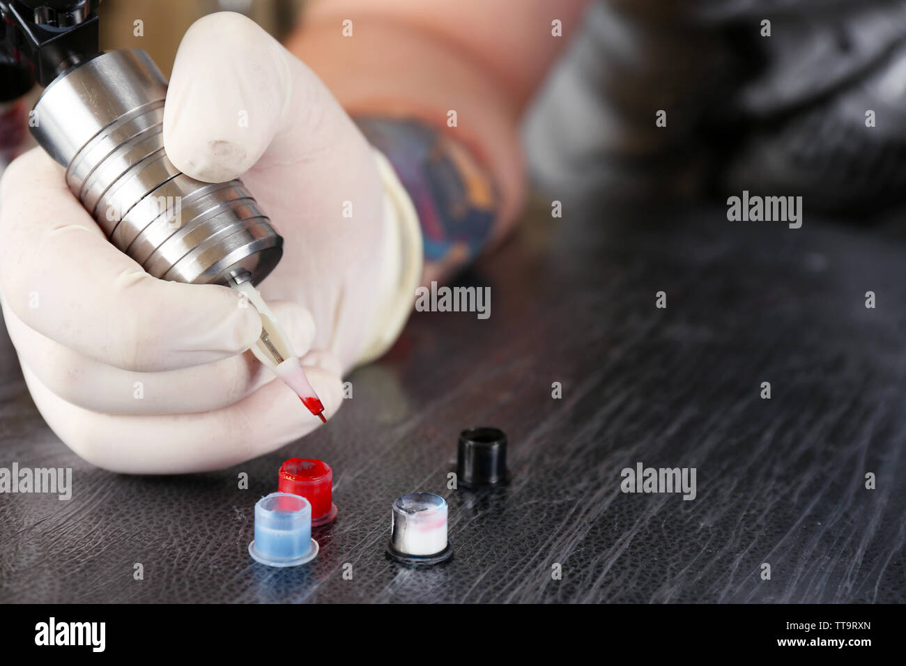 Tattoo artist at work close up Stock Photo - Alamy