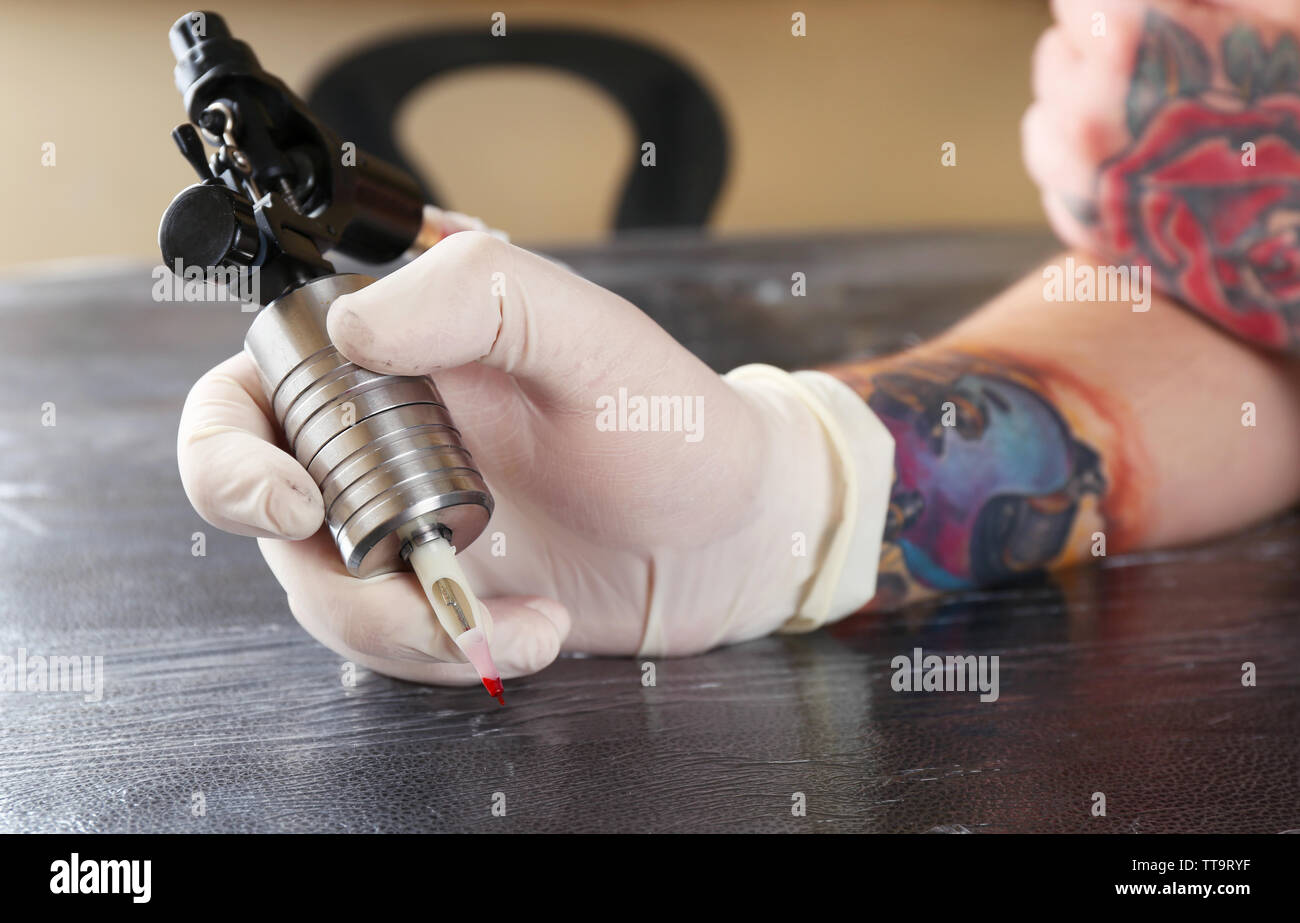 Tattoo artist at work close up Stock Photo - Alamy