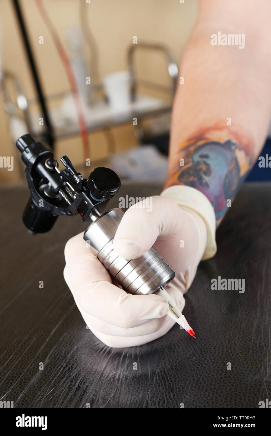 Tattoo artist at work close up Stock Photo - Alamy