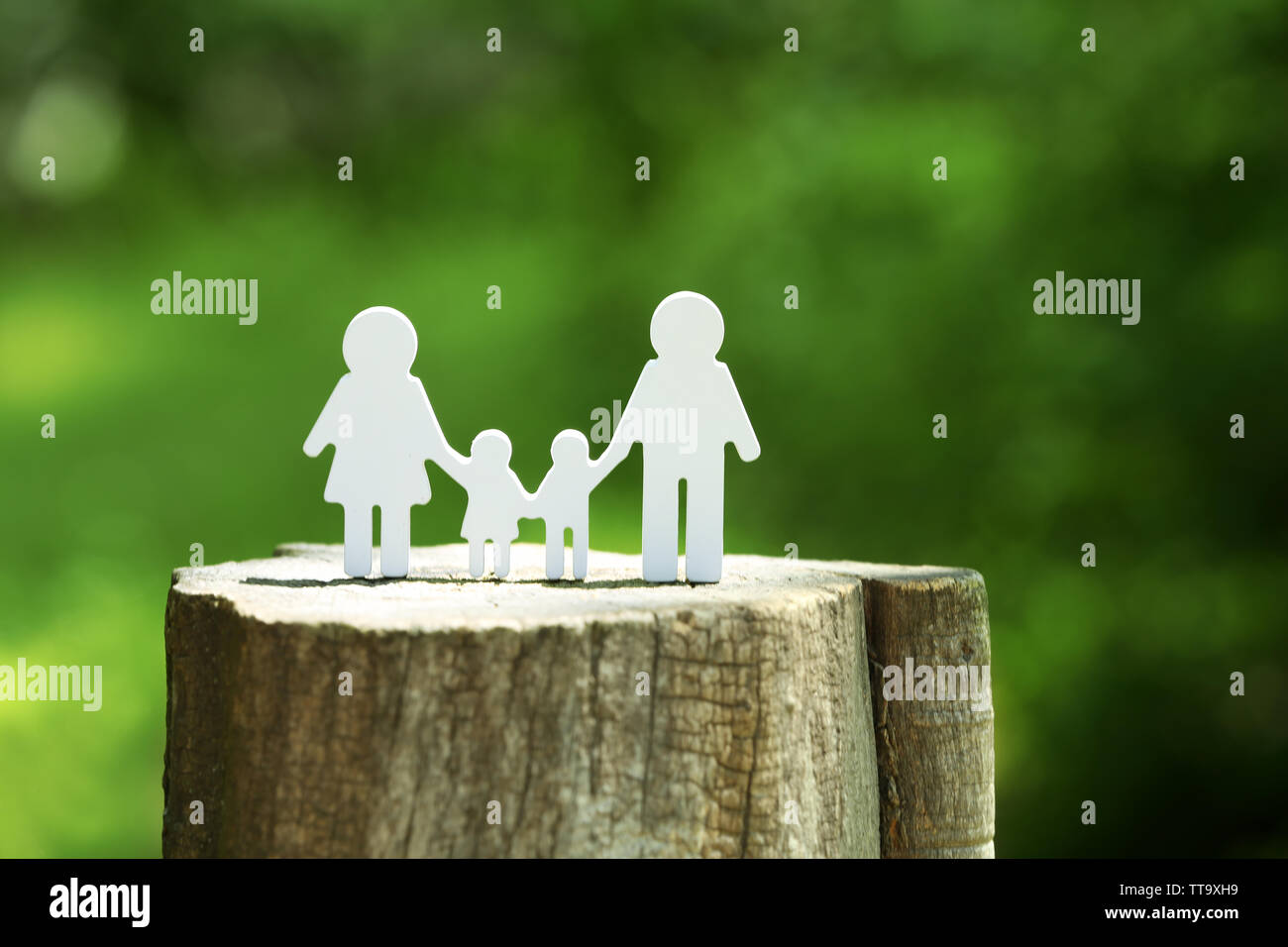 Cutout family on stump on blurred background Stock Photo - Alamy