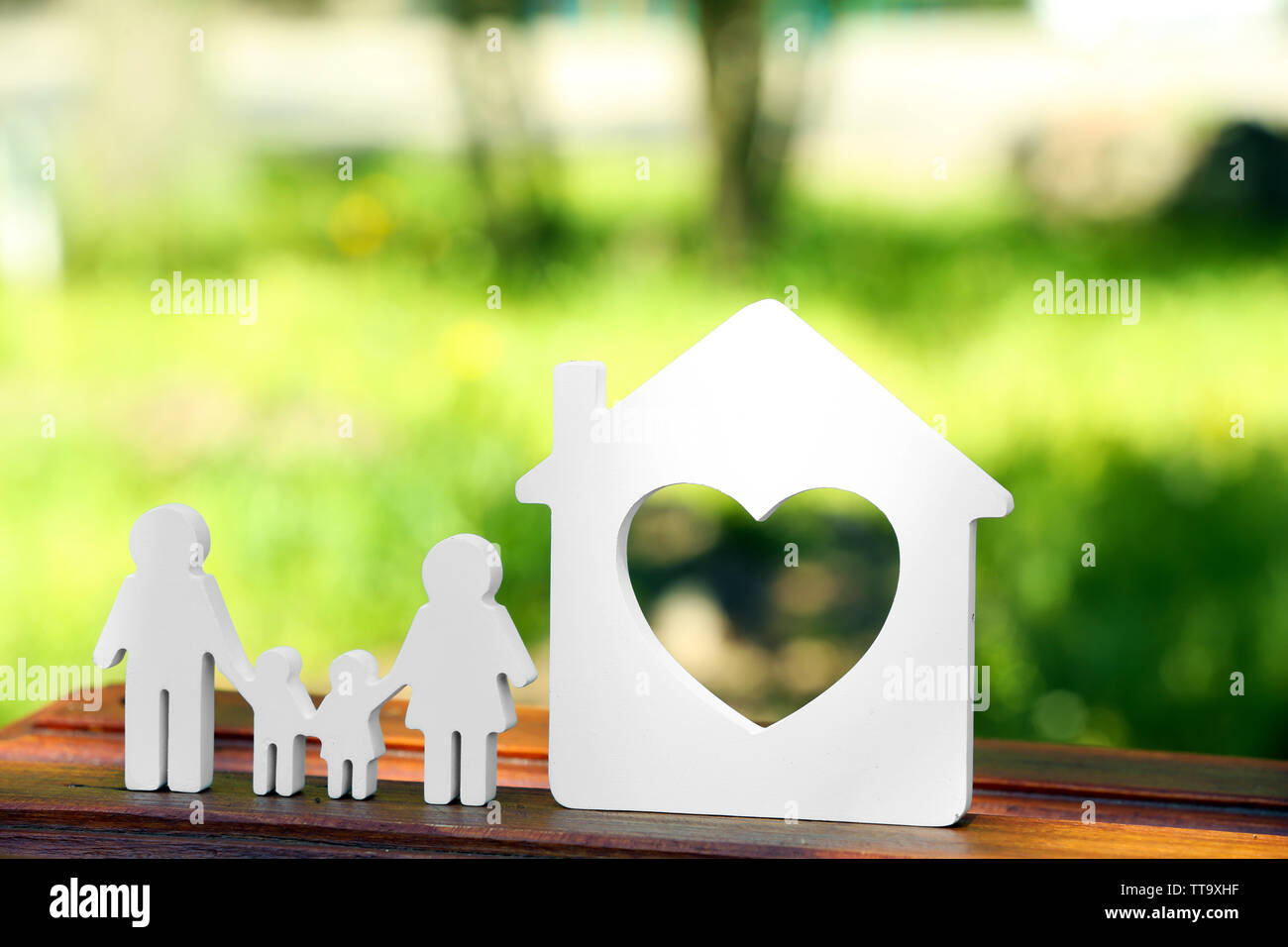 Small model of house and family on blurred background Stock Photo - Alamy