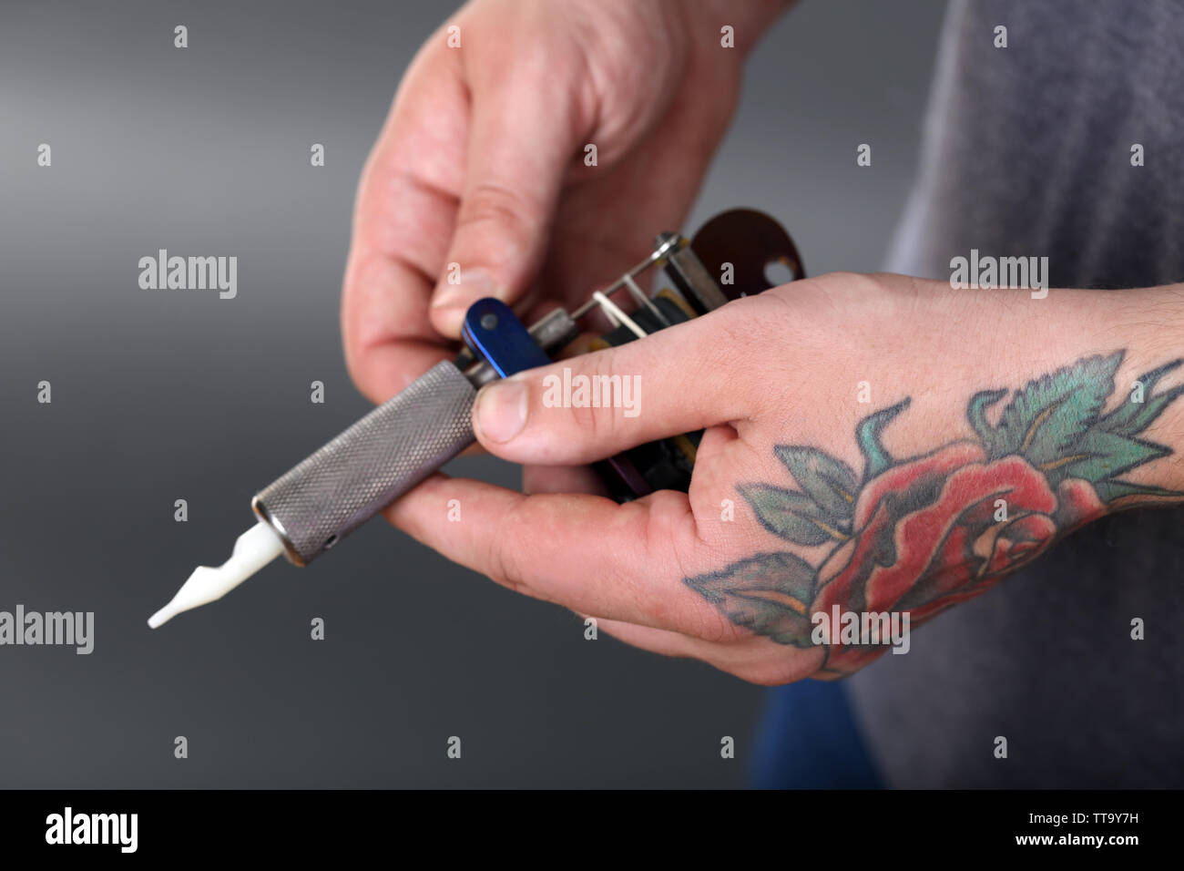 Hand of tattoo artist with tattoo machine, closeup Stock Photo - Alamy