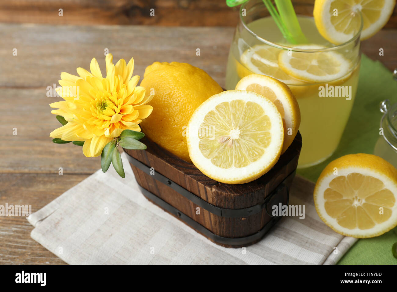 Still life with lemon juice and sliced lemons on wooden background ...