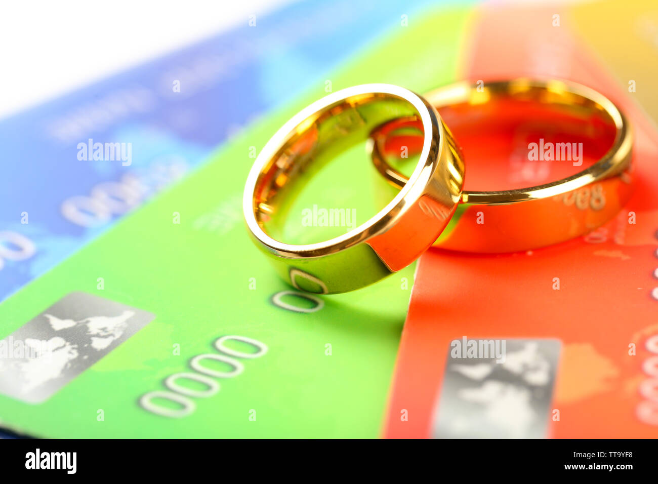 Golden wedding rings and credit card, close up. Marriage of convenience ...