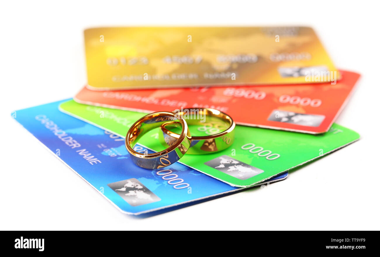 Golden wedding rings and credit cards, isolated on white. Marriage of ...