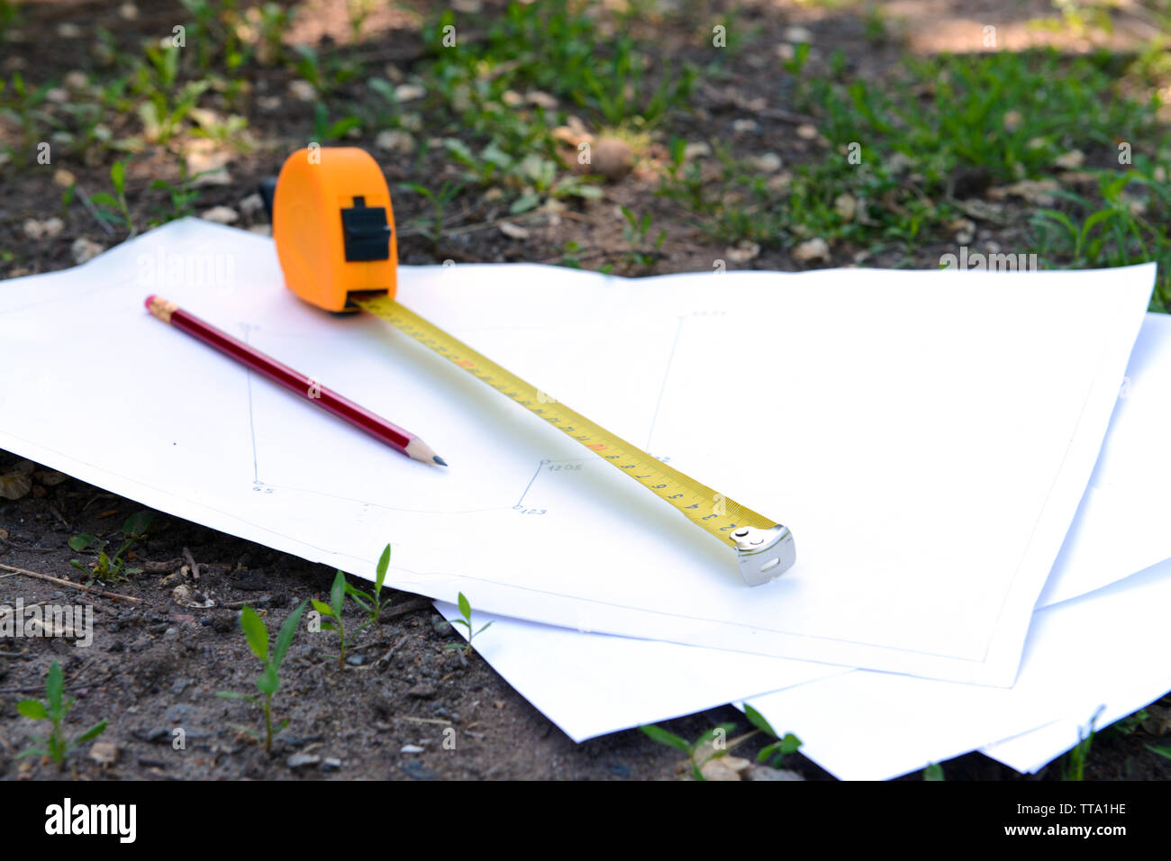 Building roulette and pencil on white sheets of paper, outdoors Stock ...