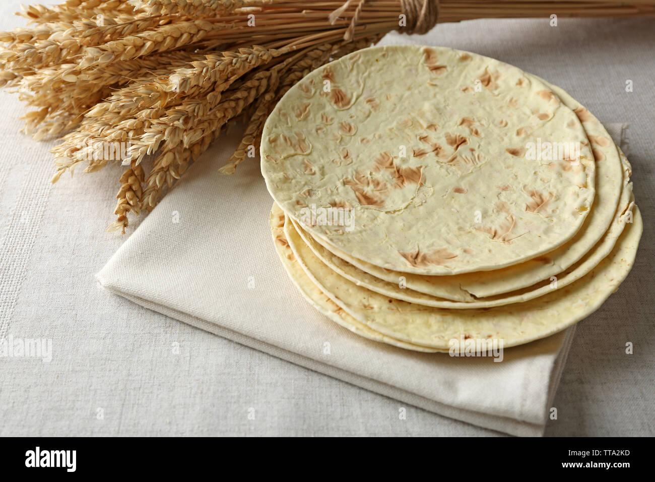 Stack of homemade whole wheat flour tortilla on napkin, on light ...