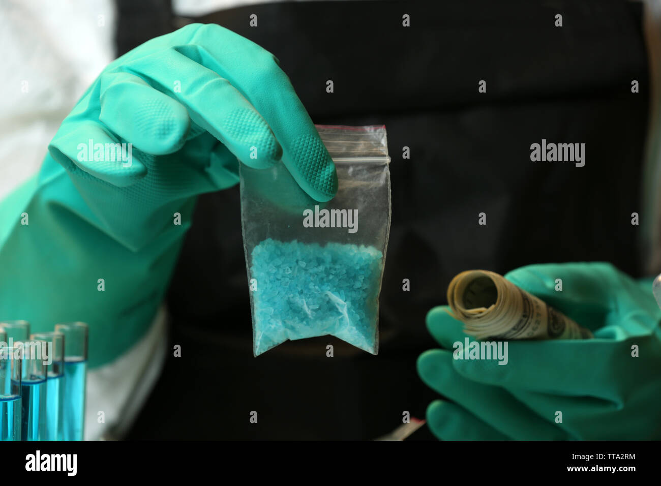 Chemists holding plastic bag with blue methamphetamine and money in ...