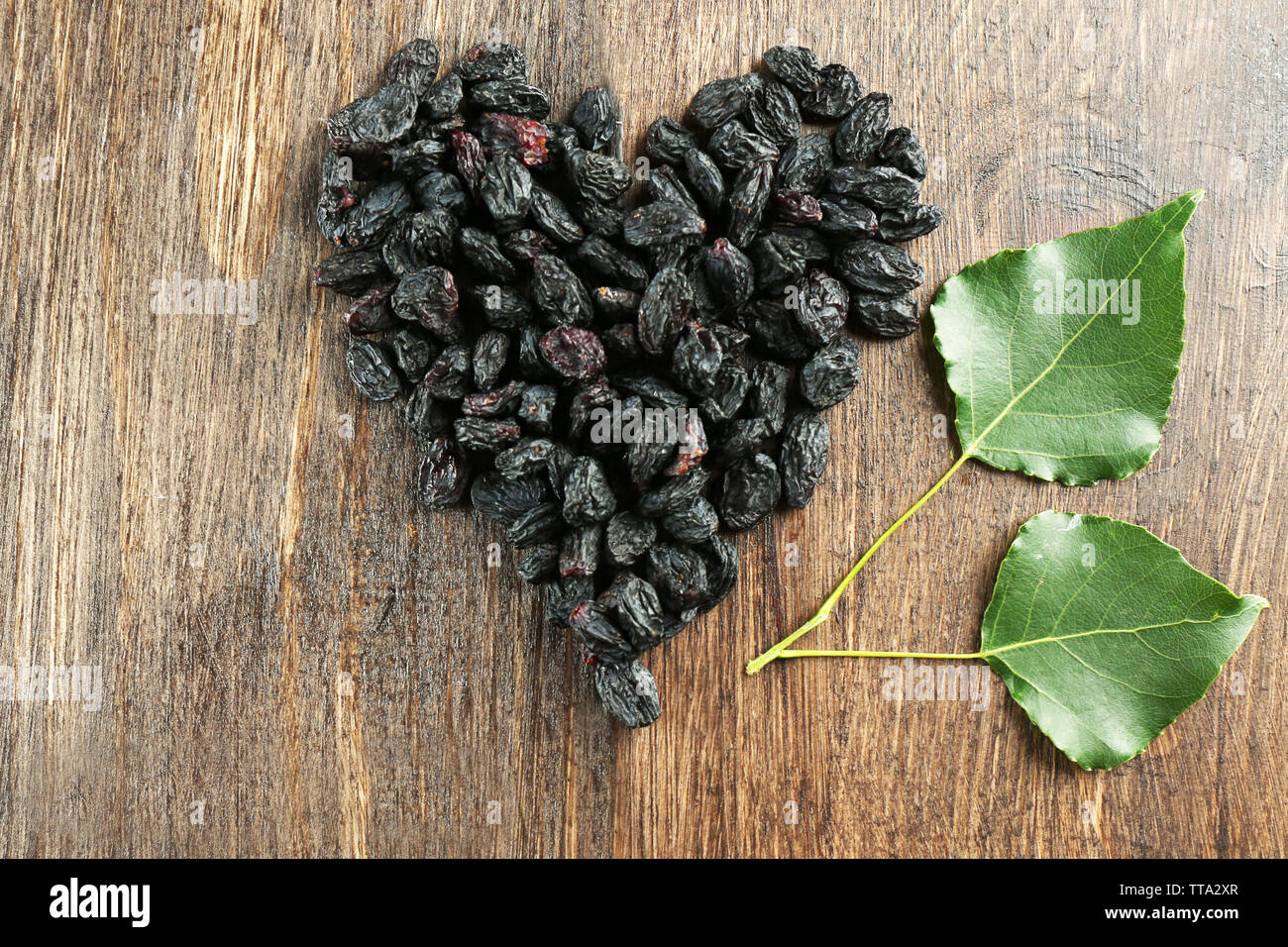 Raisins arranged in heart shape on wooden background Stock Photo - Alamy