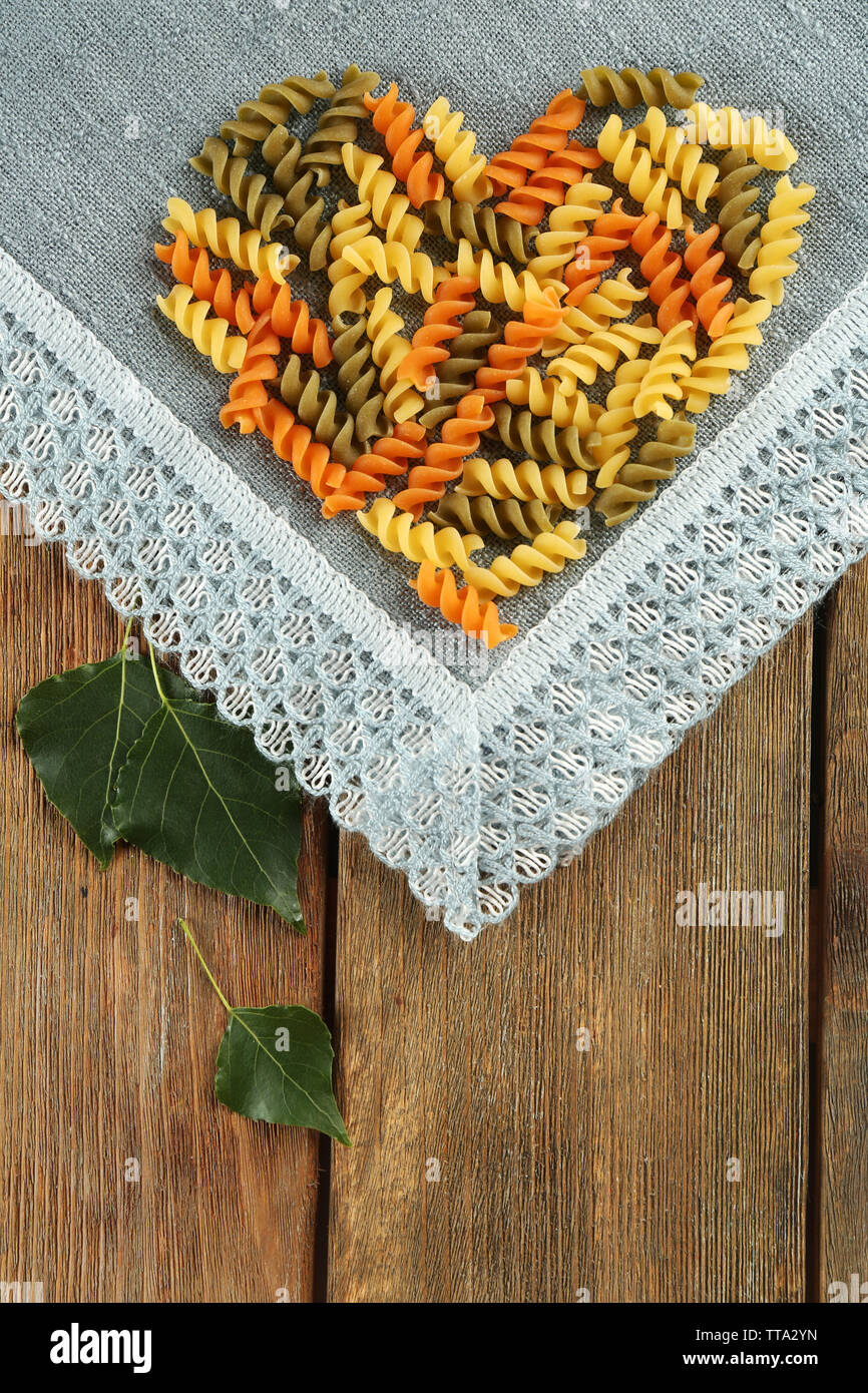 Row pasta arranged in heart shape on fabric background Stock Photo - Alamy