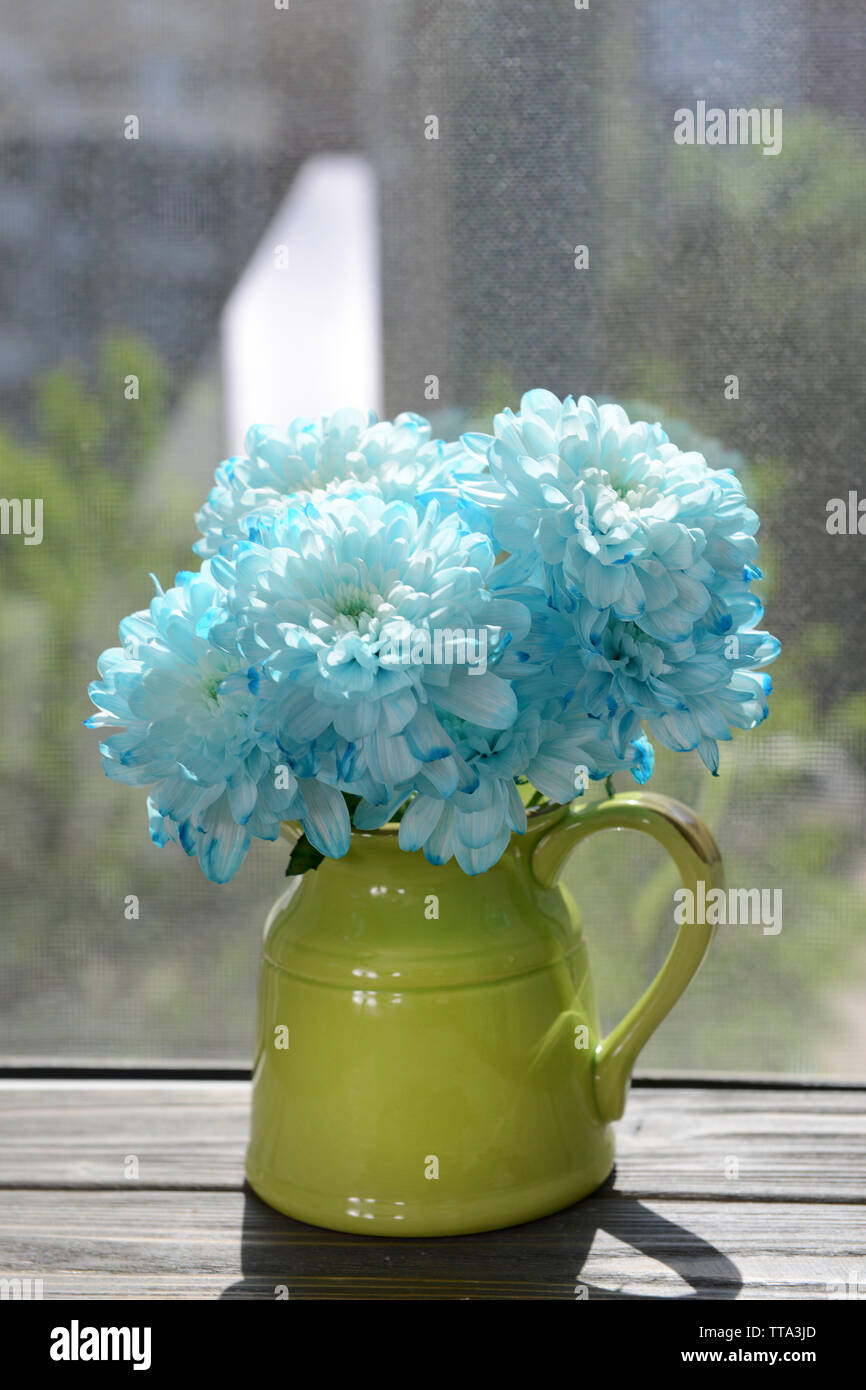 Beautiful flowers in pitcher on windowsill Stock Photo - Alamy