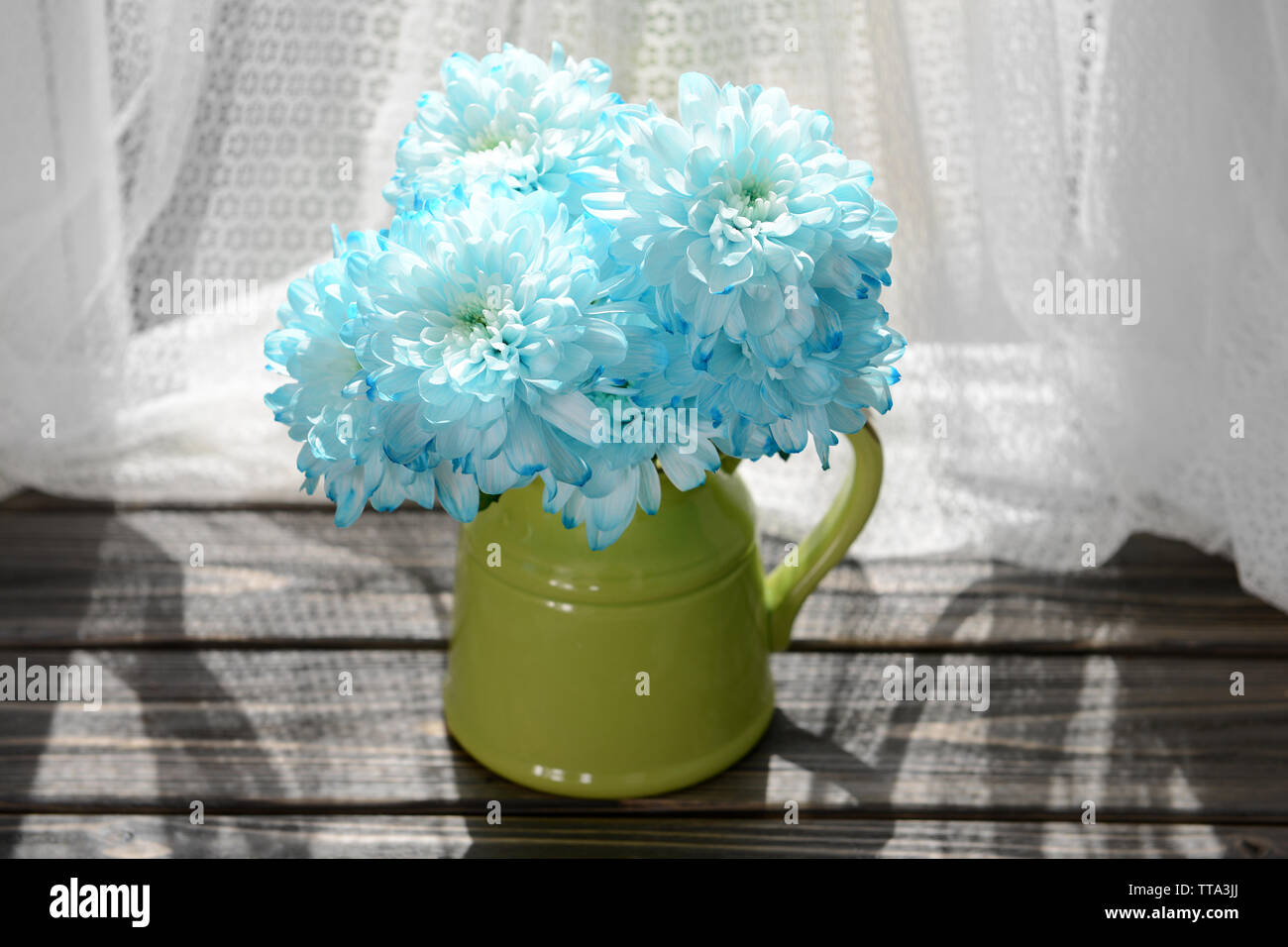 Beautiful chrysanthemums in pitcher on fabric background Stock Photo ...