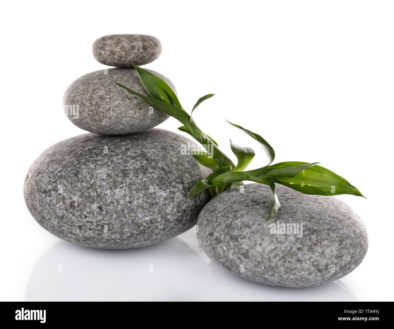 Stack of spa stones with green leaves isolated on white Stock Photo - Alamy