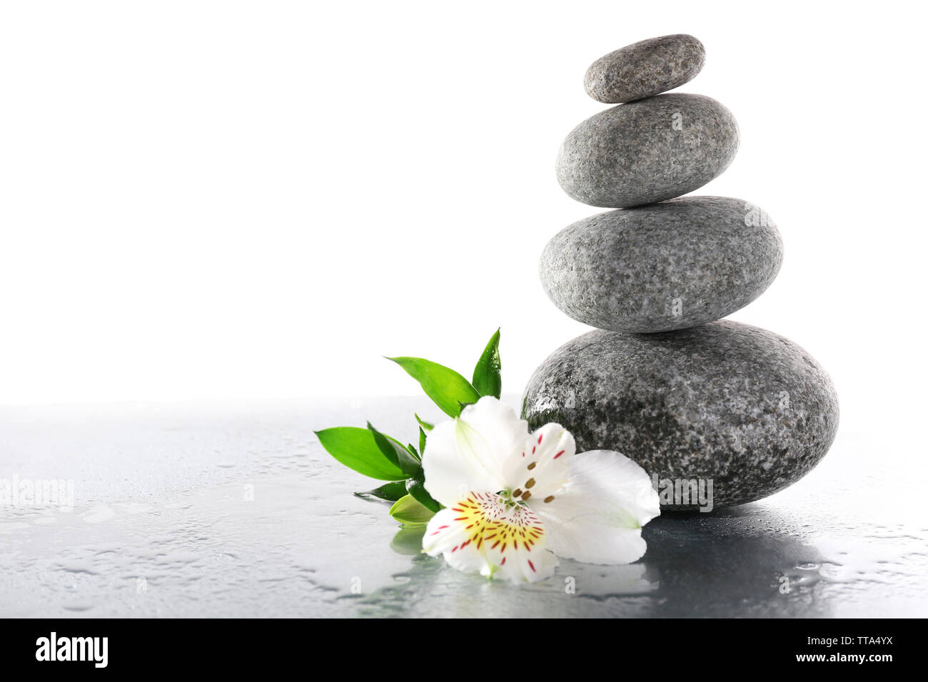 Stack of spa stones with flower isolated on white Stock Photo - Alamy