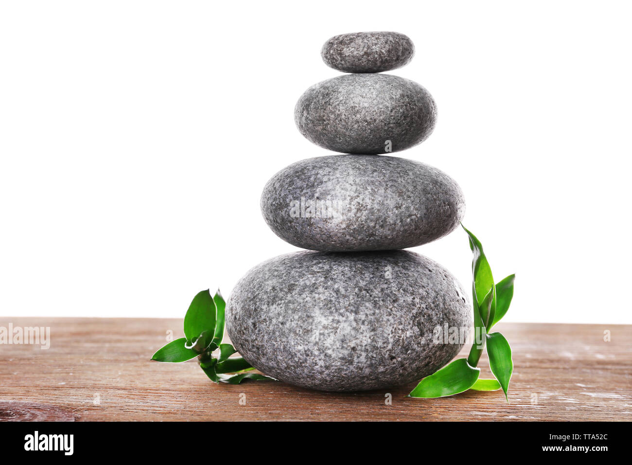 Stack of spa stones with green leaves isolated on white Stock Photo - Alamy
