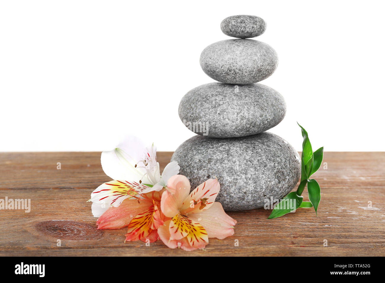 Stack of spa stones with flower isolated on white Stock Photo - Alamy