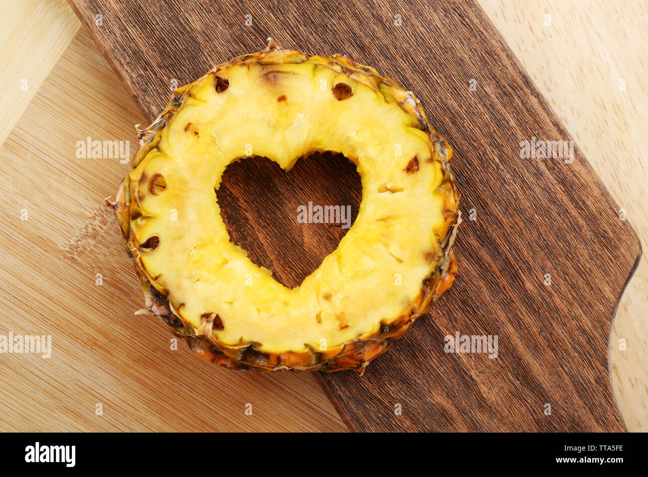 Pineapple slice with cut in shape of heart on wooden background Stock ...