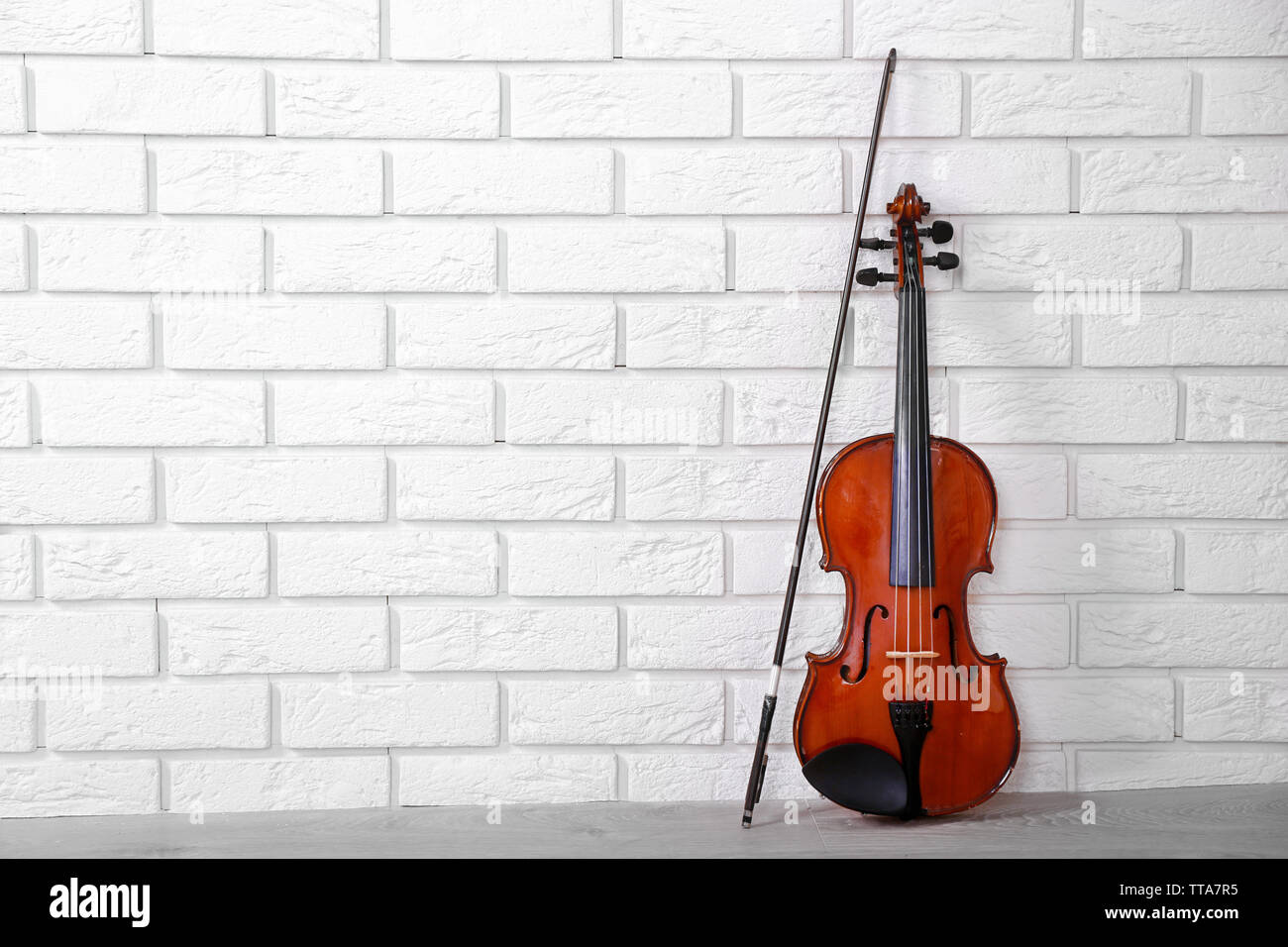 Violin on bricks wall background Stock Photo - Alamy