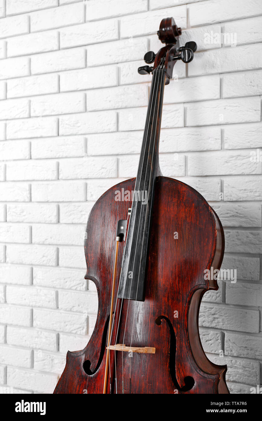 Cello on bricks wall background Stock Photo - Alamy