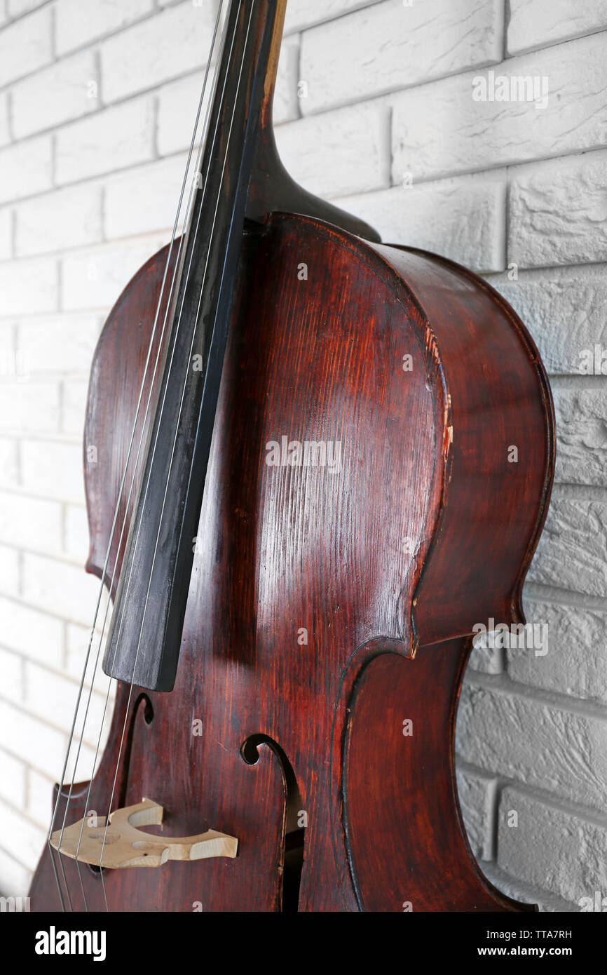 Cello on bricks wall background Stock Photo - Alamy