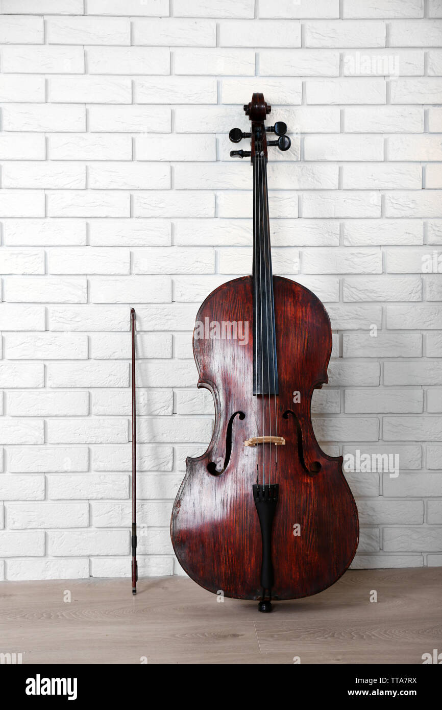 Cello on bricks wall background Stock Photo - Alamy
