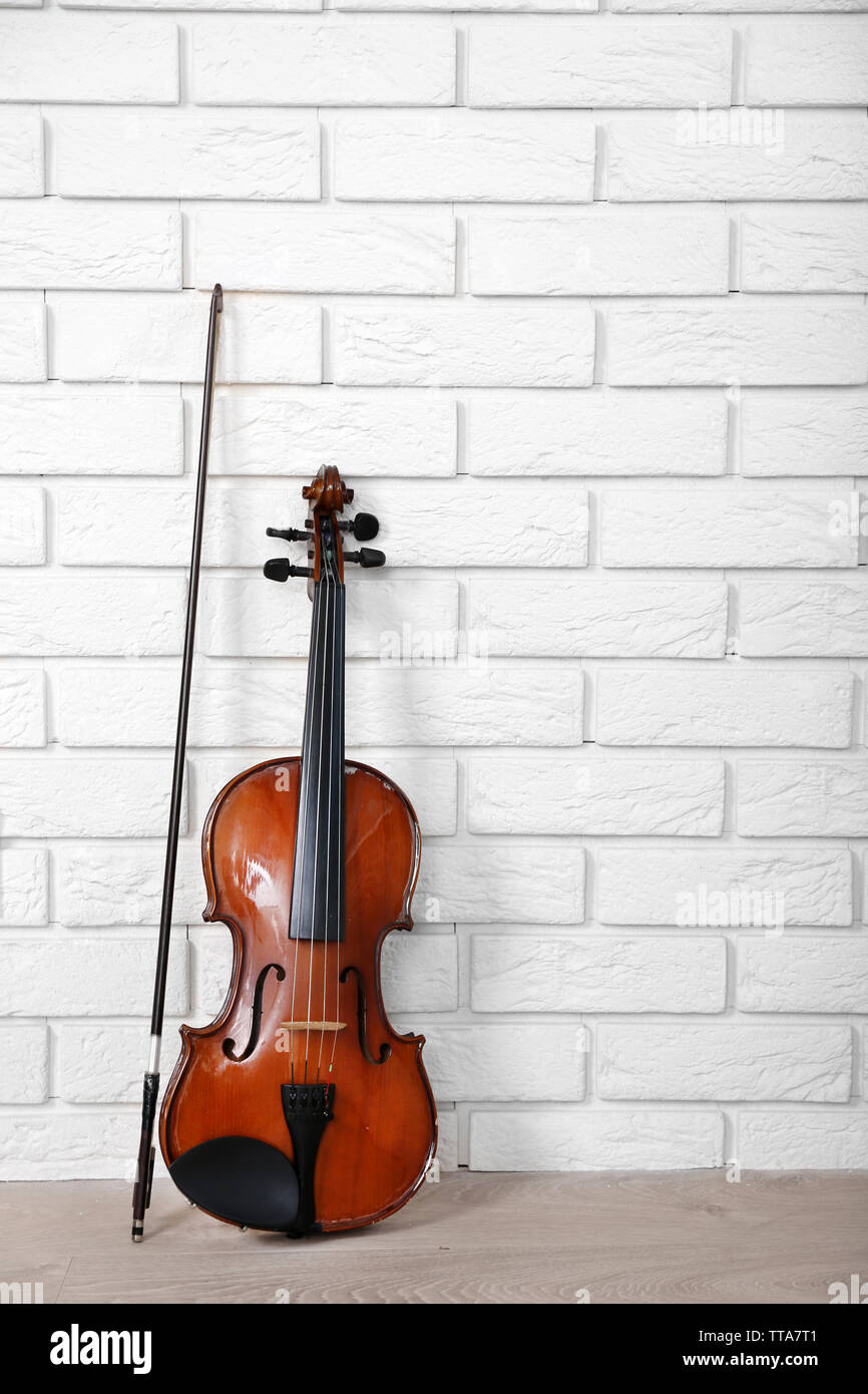 Violin on bricks wall background Stock Photo - Alamy