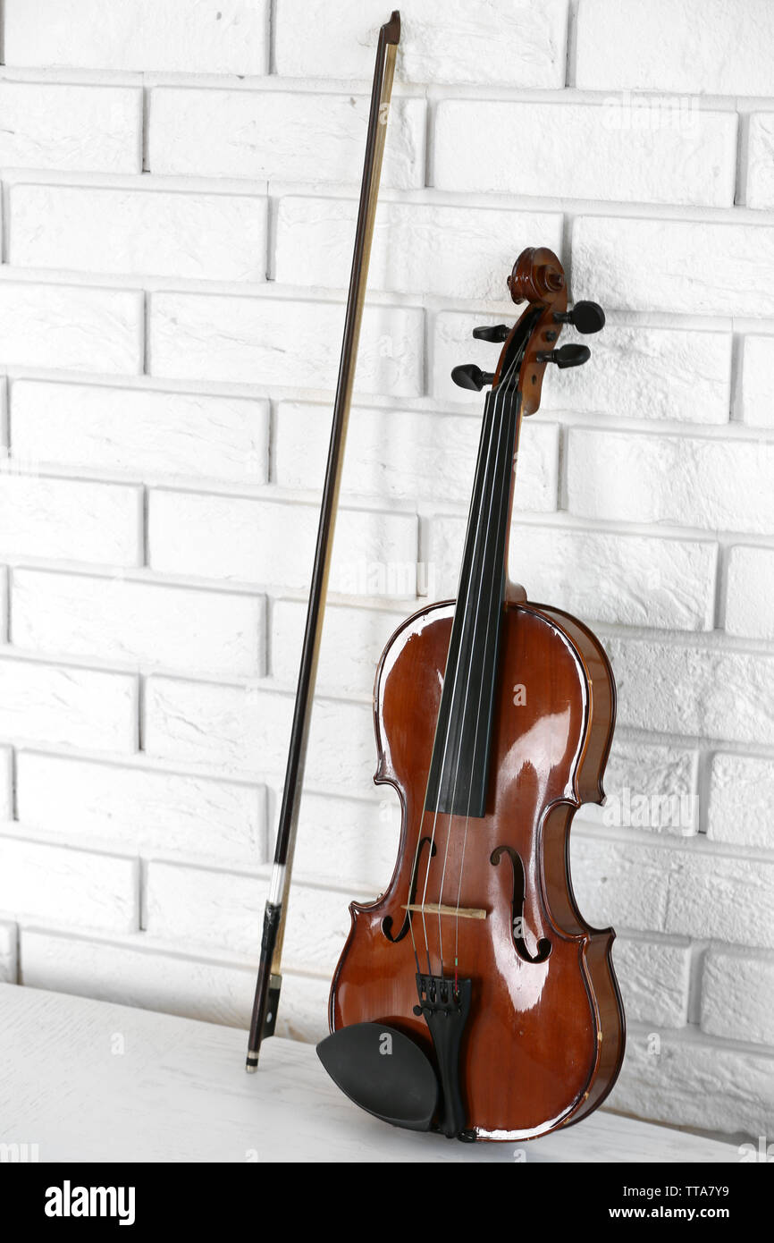 Violin on bricks wall background Stock Photo - Alamy