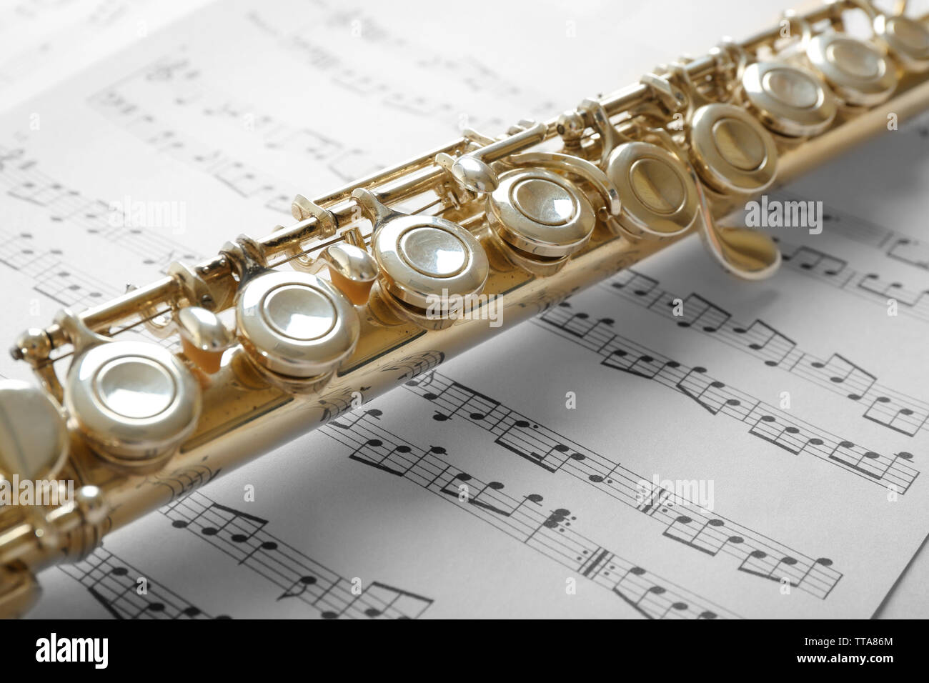 Flute on music notes background Stock Photo - Alamy