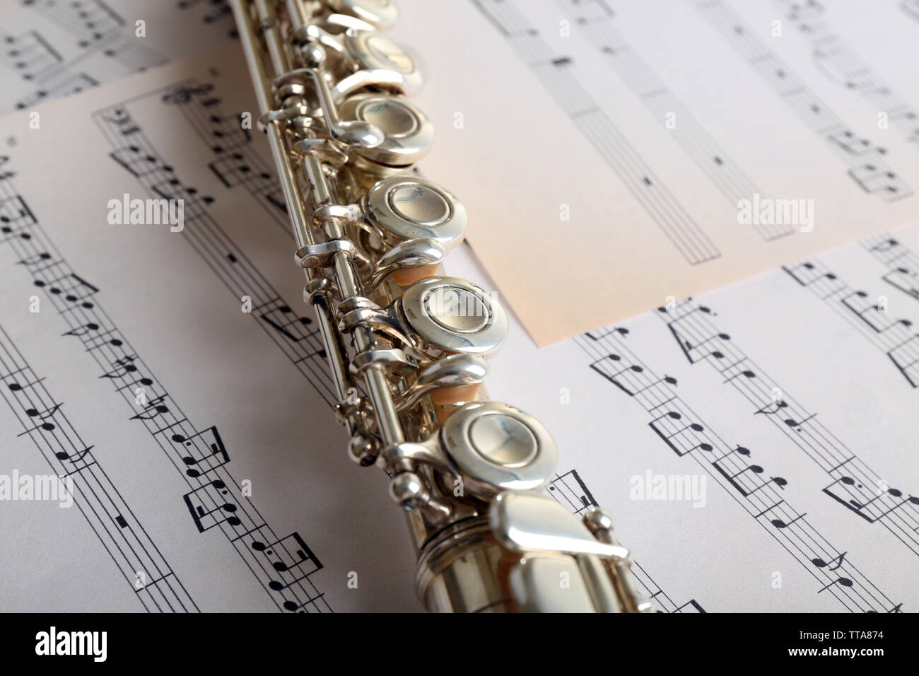 Flute on music notes background Stock Photo - Alamy