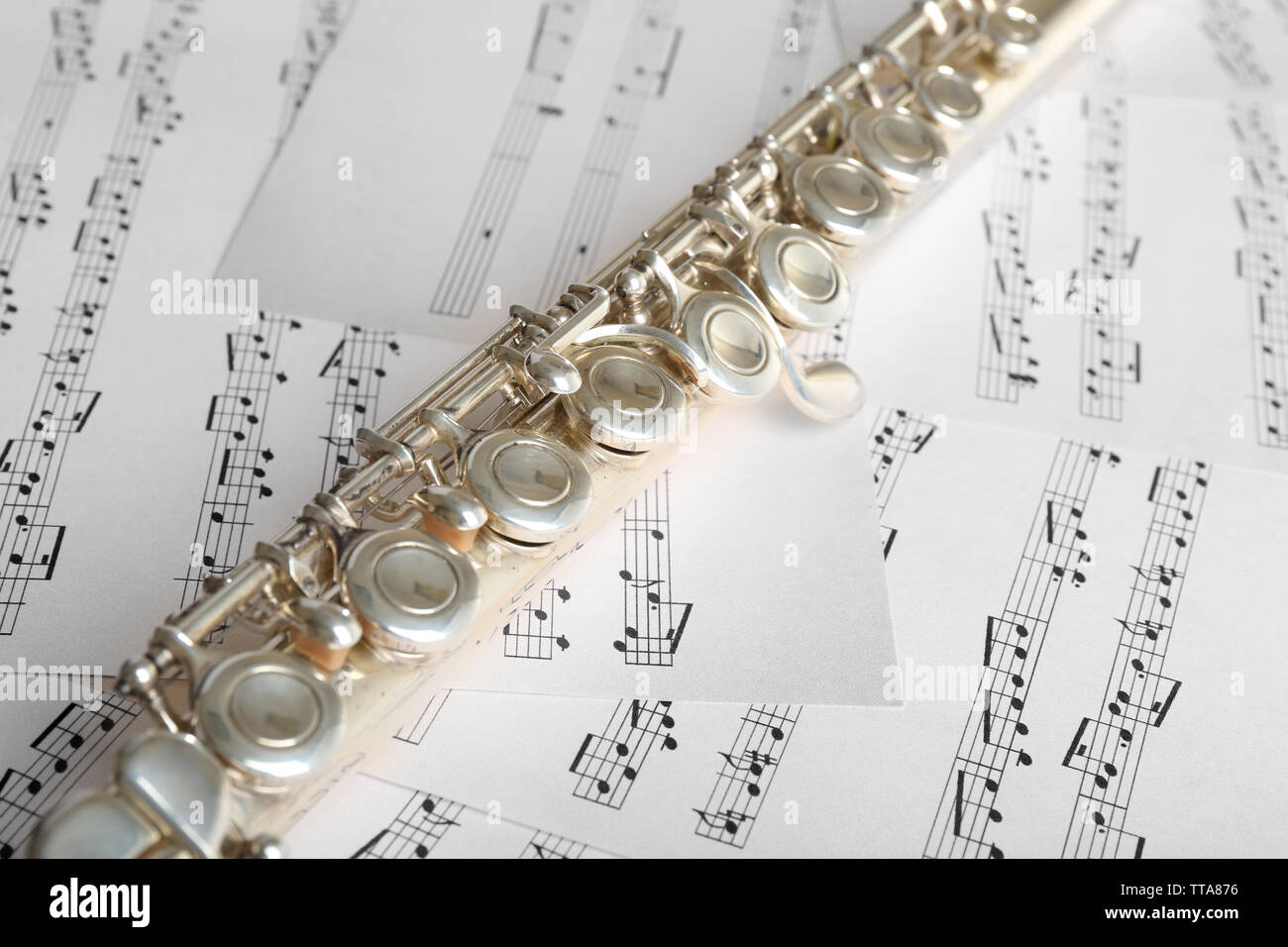 Flute on music notes background Stock Photo - Alamy