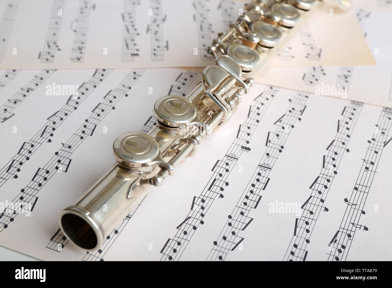 Flute on music notes background Stock Photo - Alamy