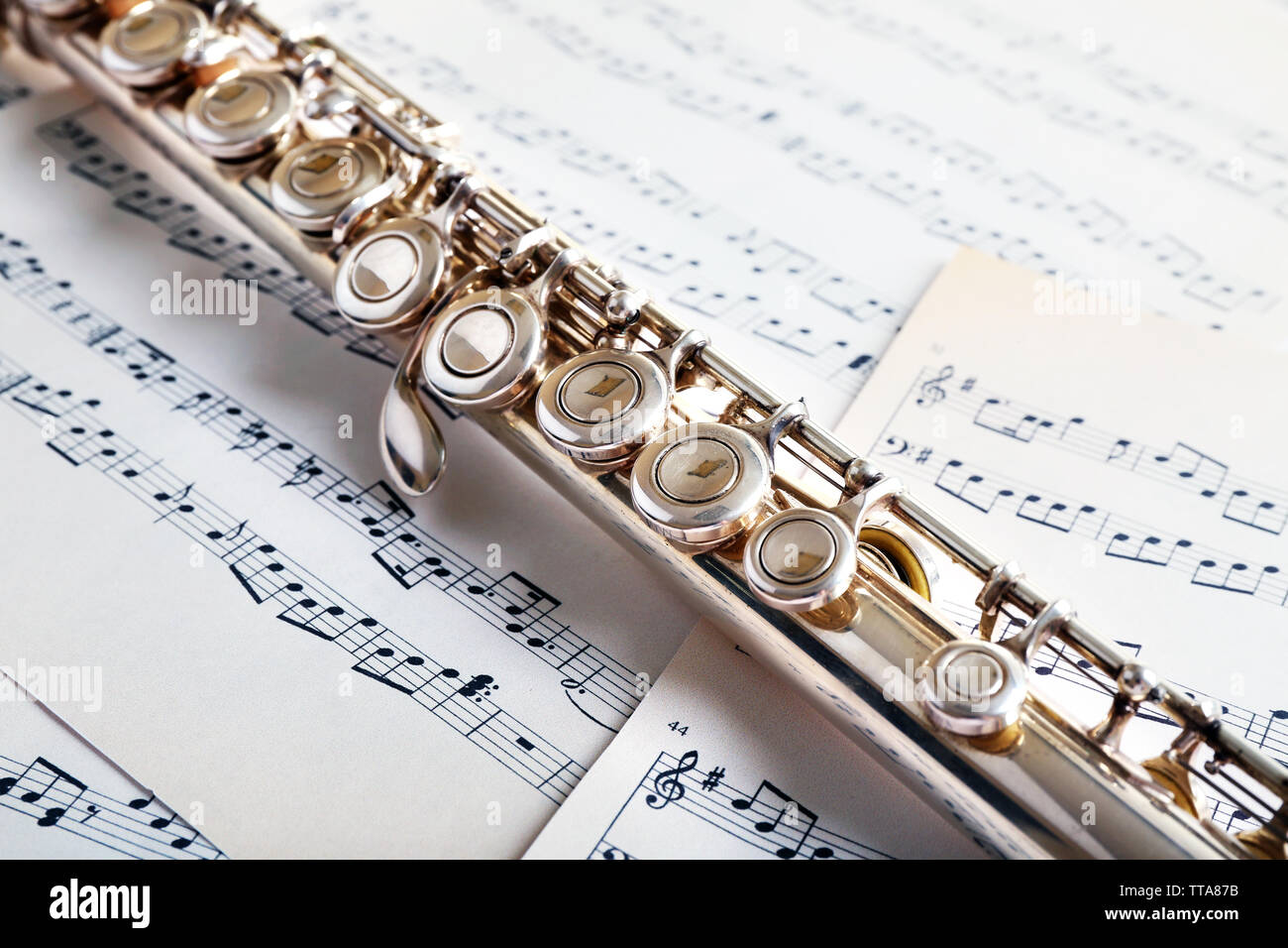 Flute on music notes background Stock Photo - Alamy