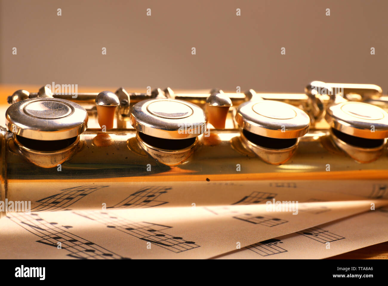 Silver flute with music notes on gray background Stock Photo - Alamy