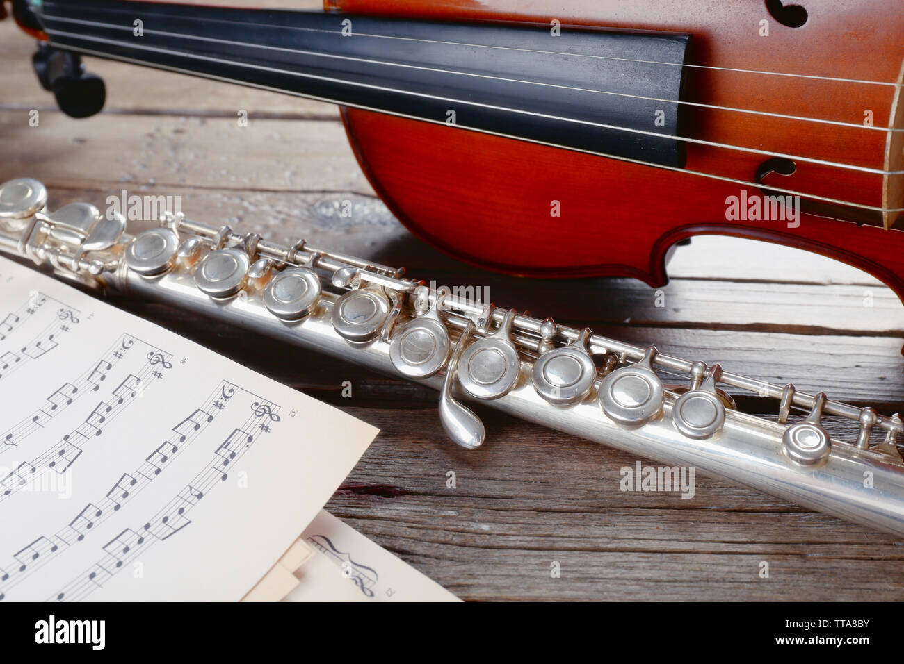 Flute and violin with music notes on wooden table close up Stock Photo ...