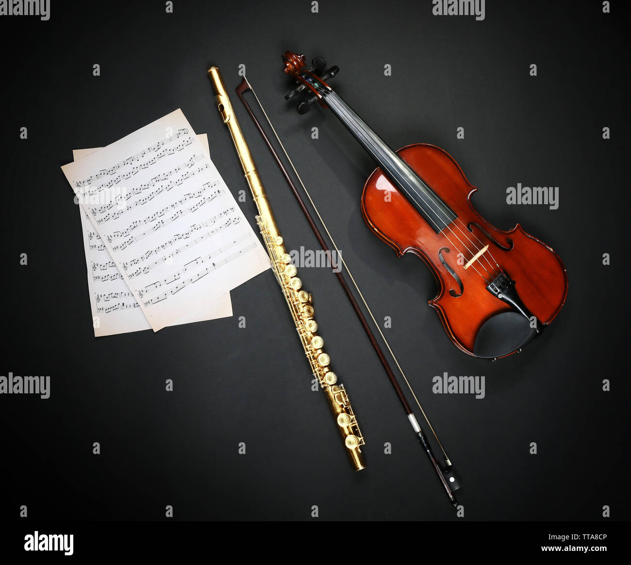 Violin and flute with music notes on dark background Stock Photo - Alamy