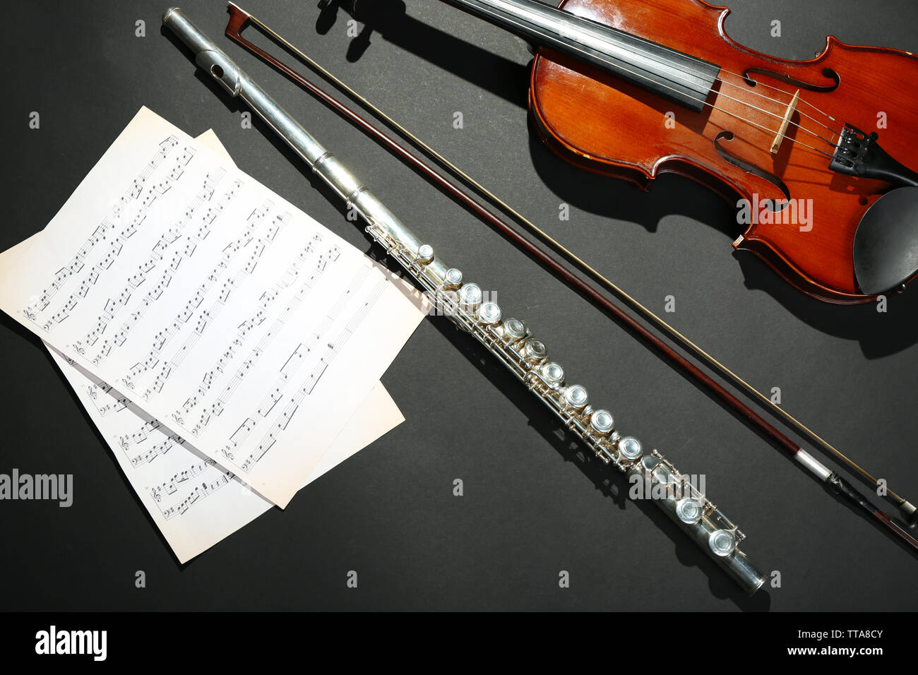 Violin and flute with music notes on dark background Stock Photo - Alamy