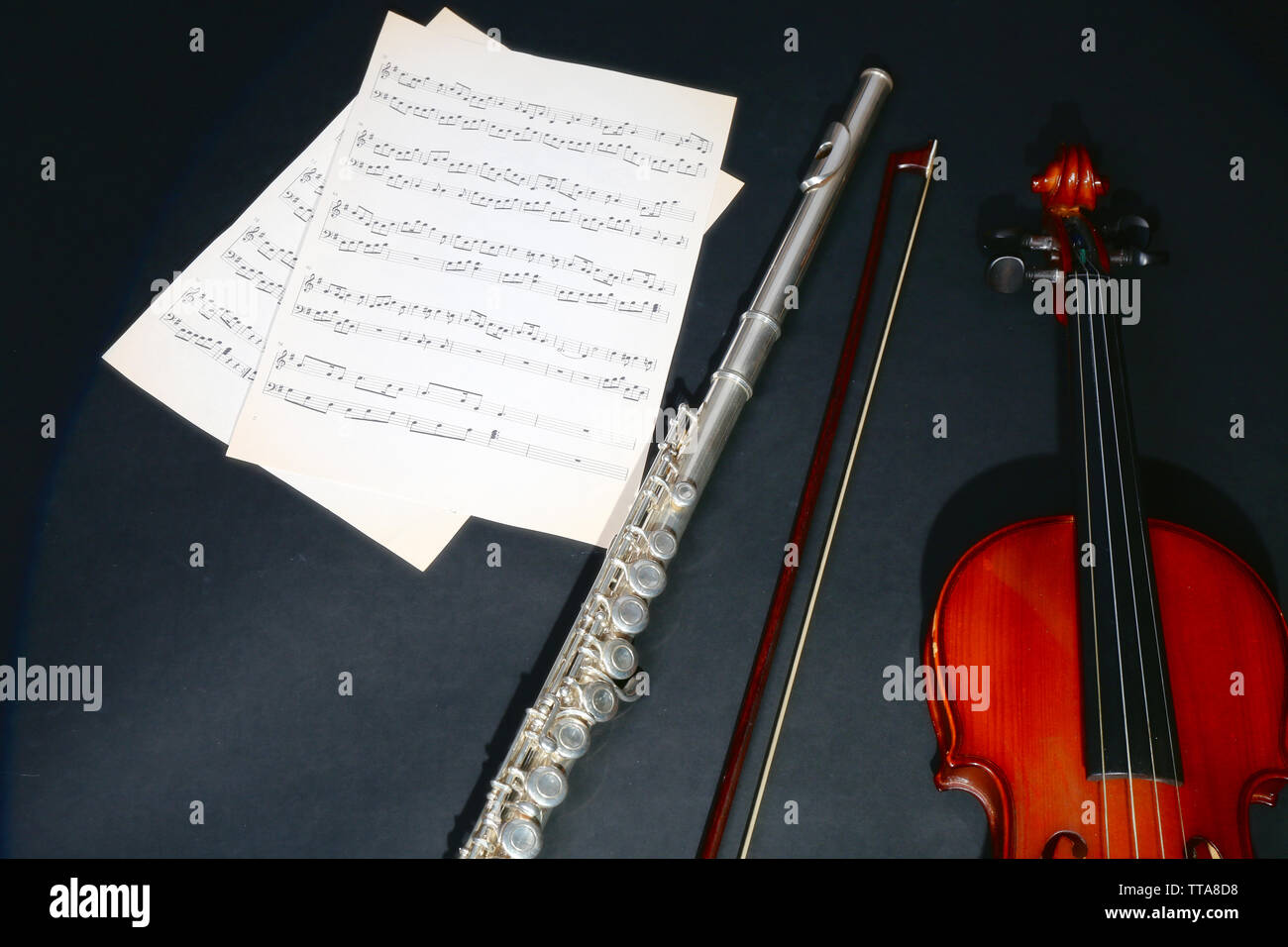 Violin and flute with music notes on dark background Stock Photo - Alamy