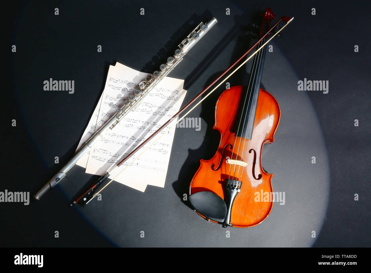 Violin and flute with music notes on dark background Stock Photo - Alamy