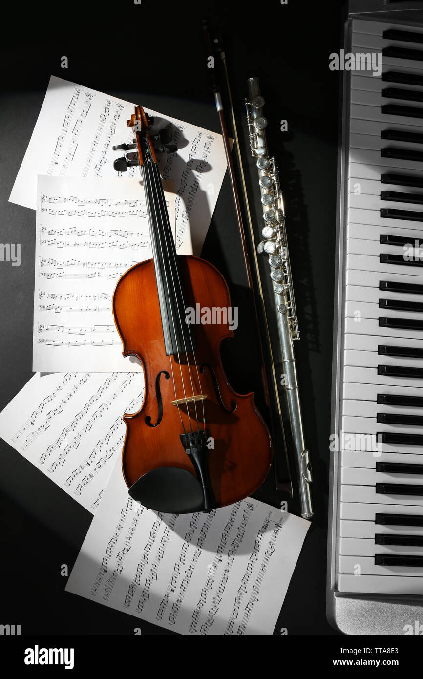 Musical instruments with music notes on dark background Stock Photo - Alamy