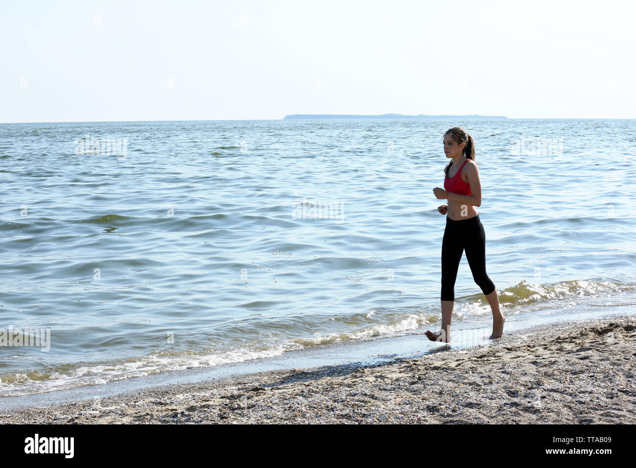 Young woman jogging on beach Stock Photo - Alamy