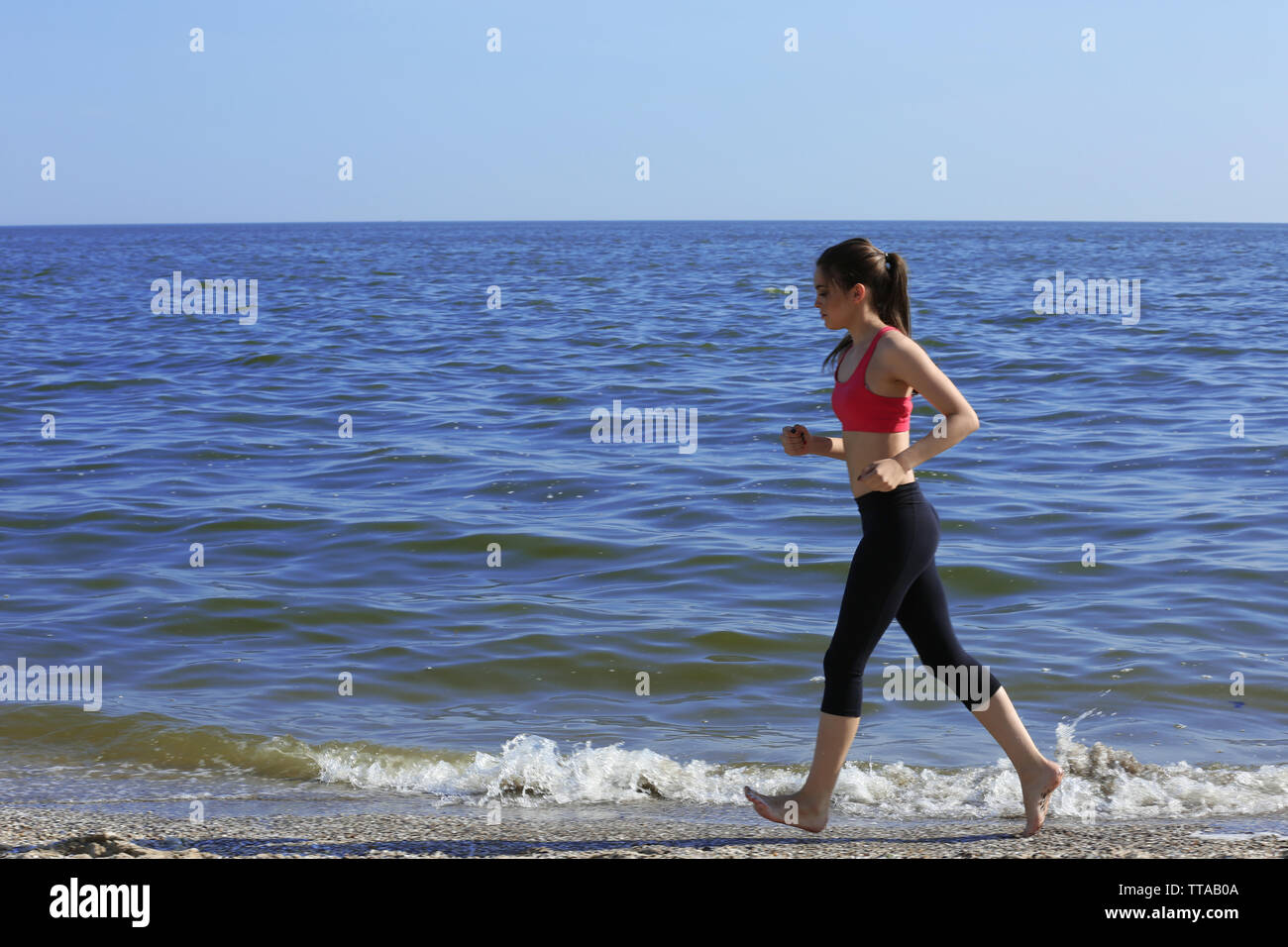 Young woman jogging on beach Stock Photo - Alamy